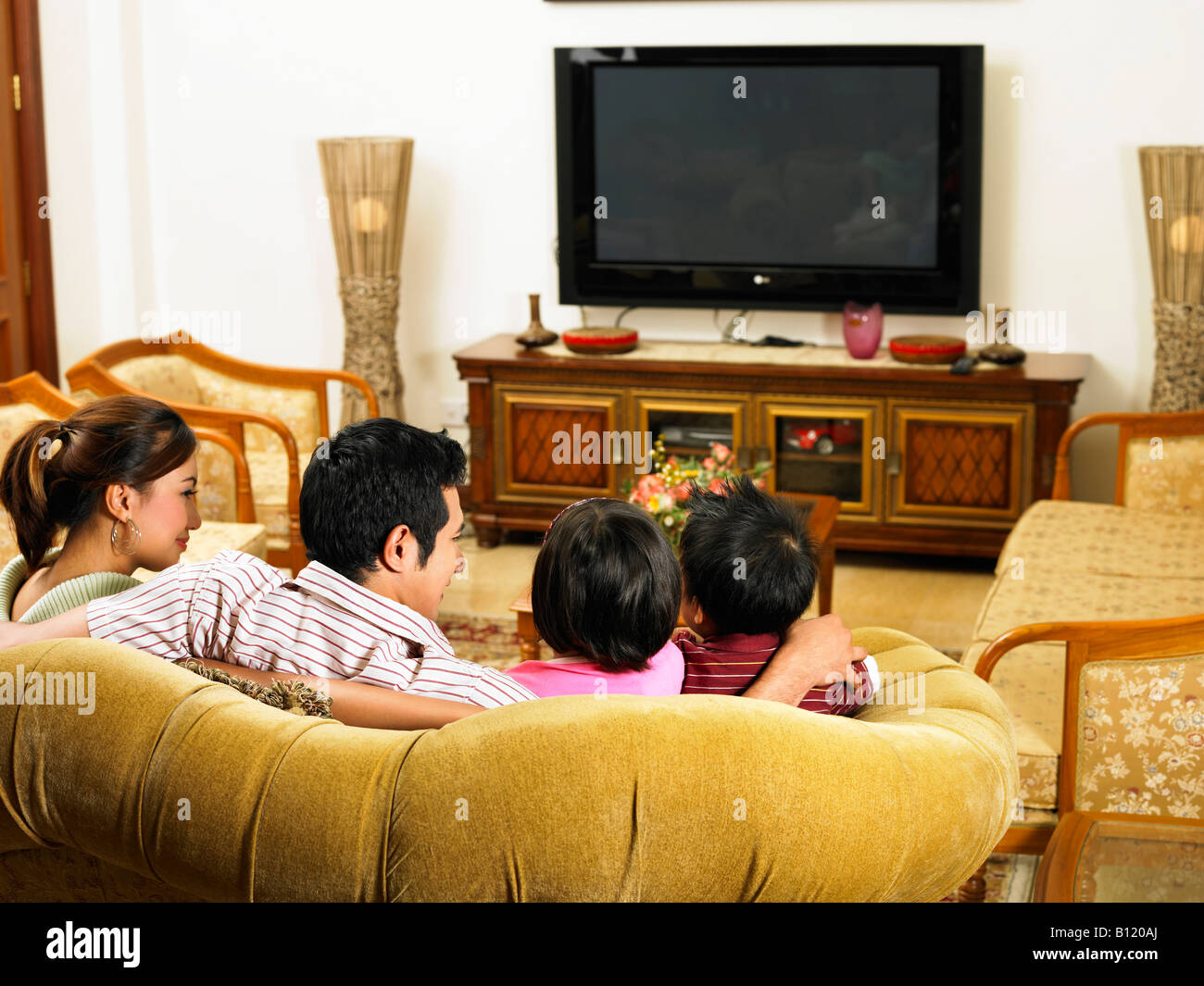 Parent with young son and daughter watching television Stock Photo - Alamy