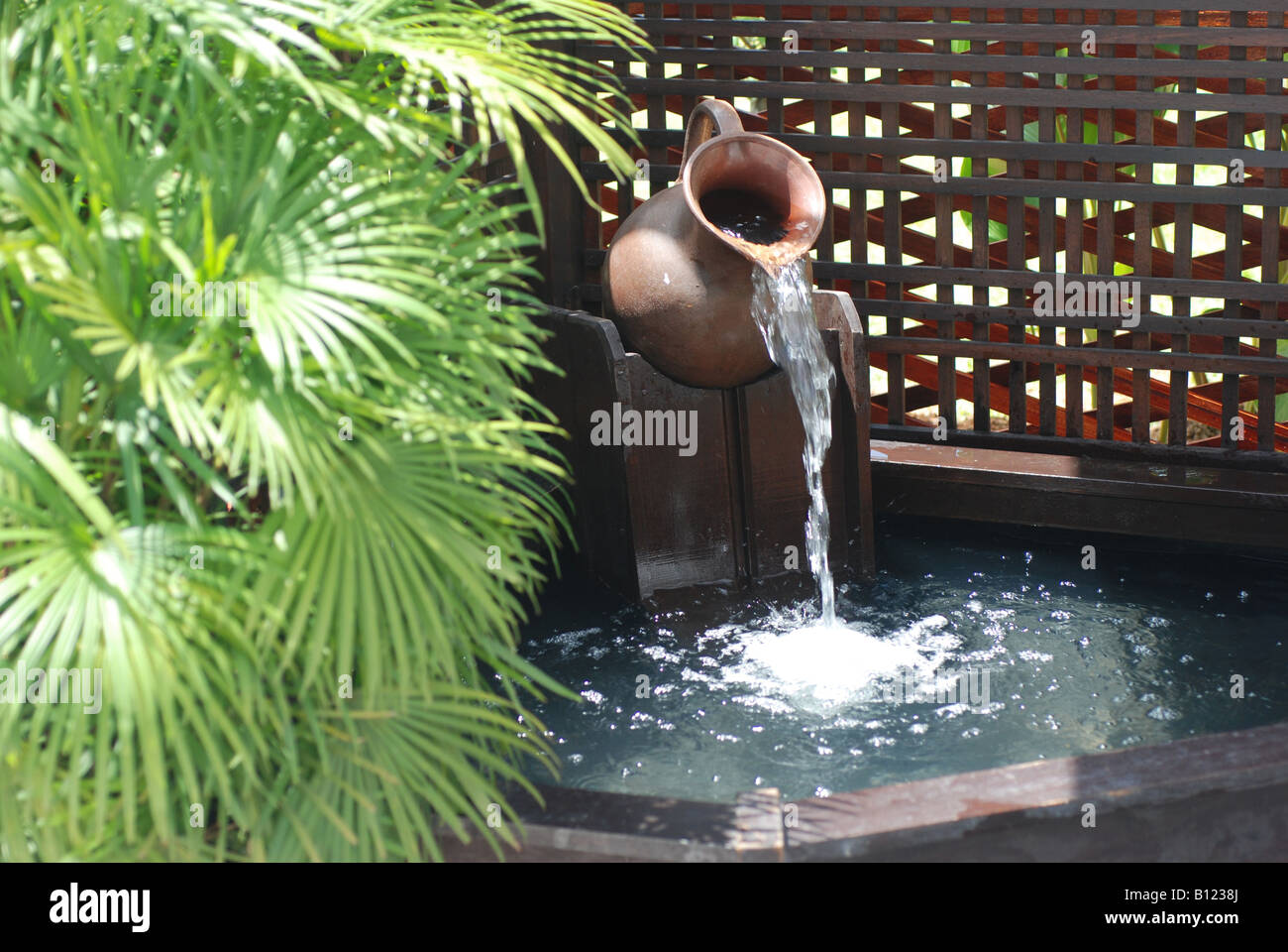 Water flowing out of pitcher in garden pond Stock Photo - Alamy