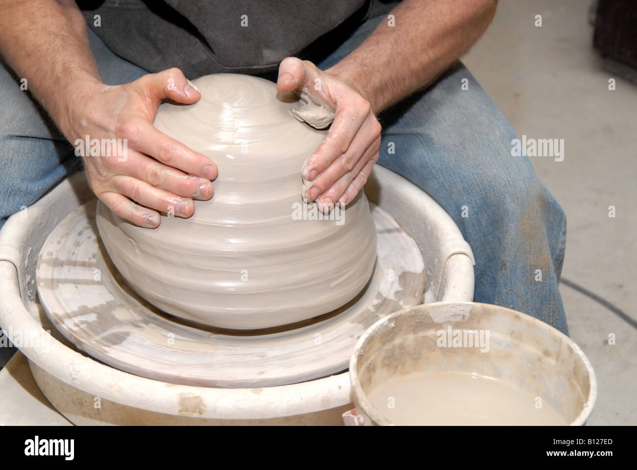 Potter centering clay on potter's wheel starting to form a pot Stock ...