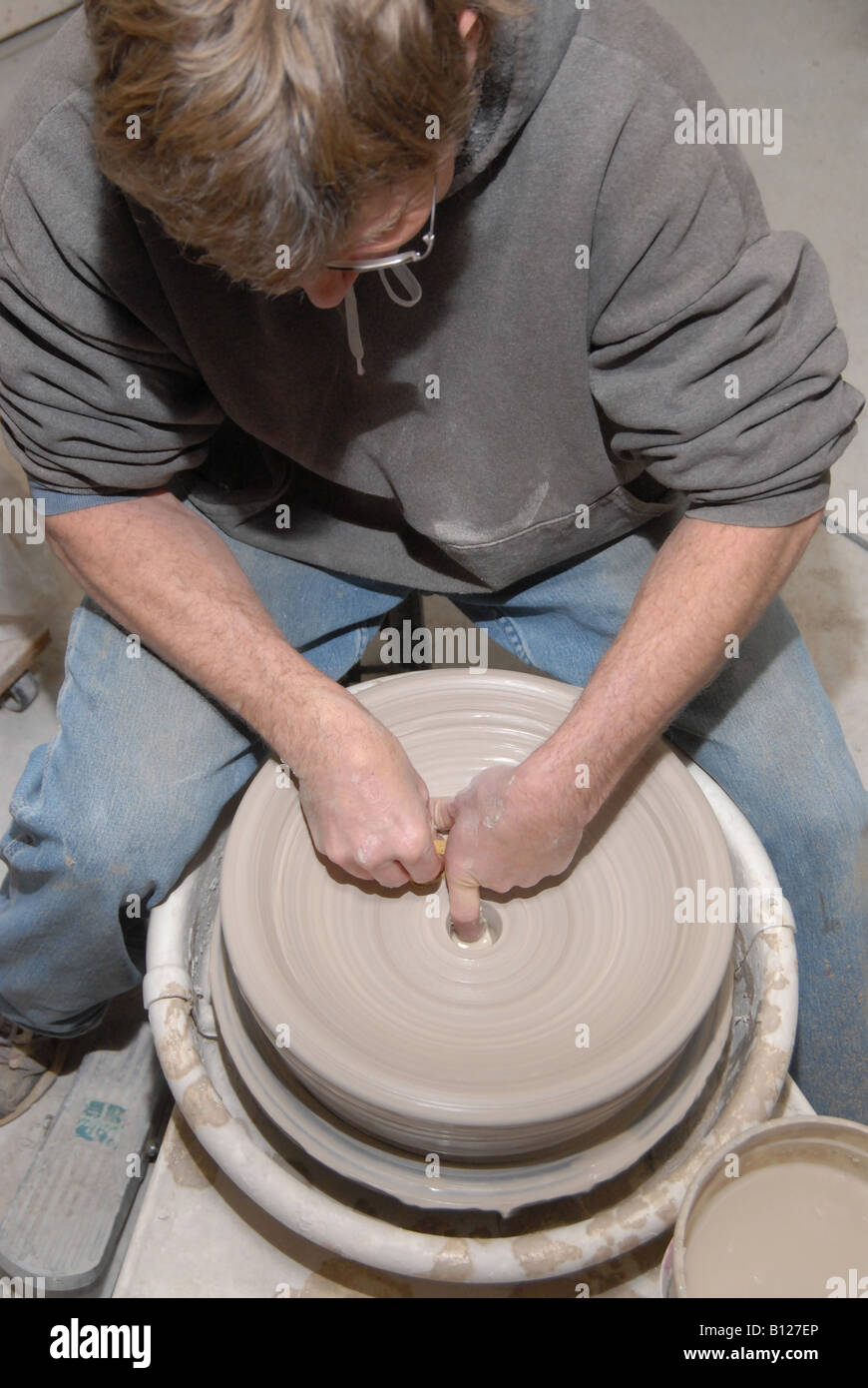 Potter forming large bowl with hands on potter's wheel Stock Photo - Alamy
