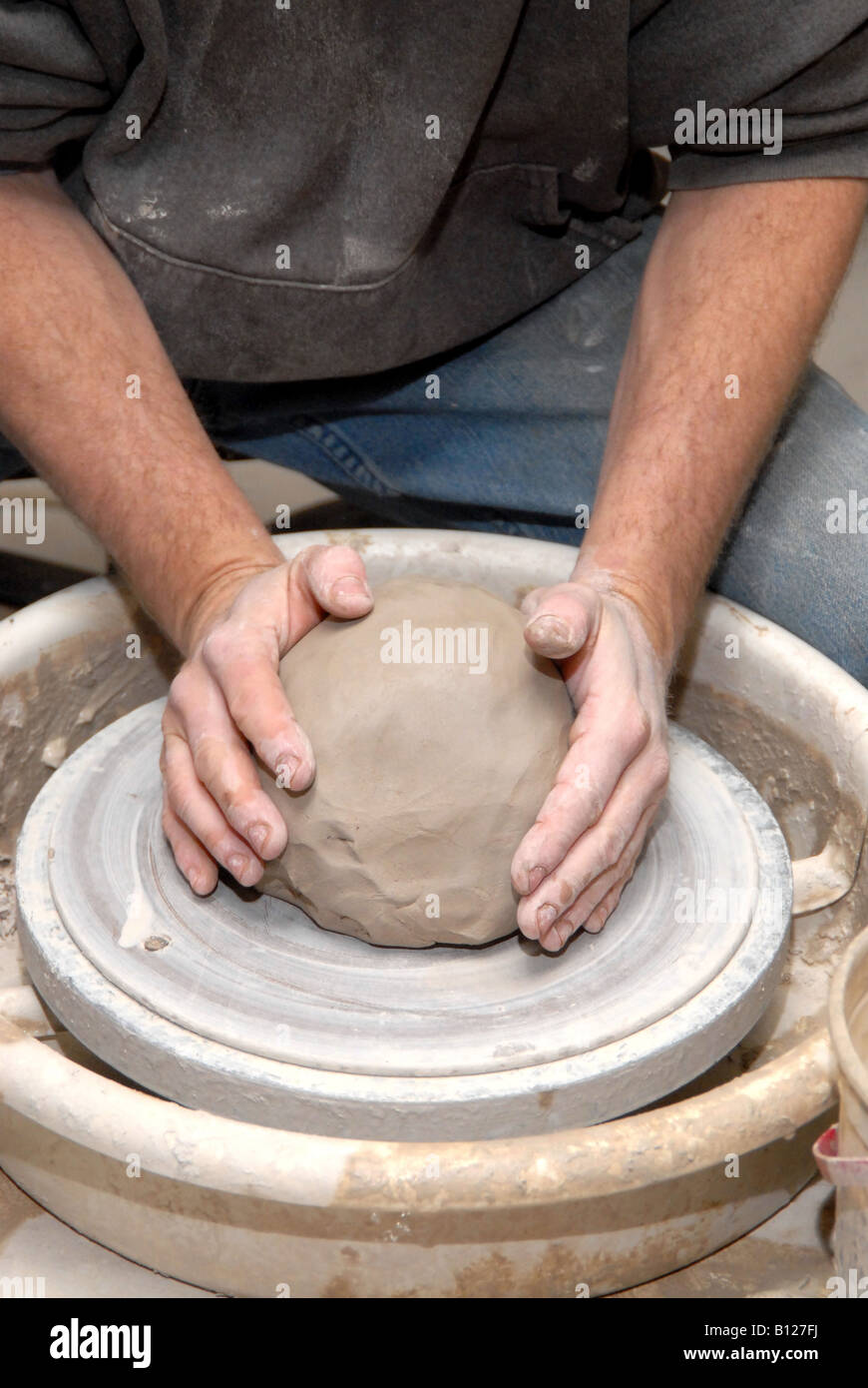 Potter centering clay on potter's wheel starting to form a pot Stock ...