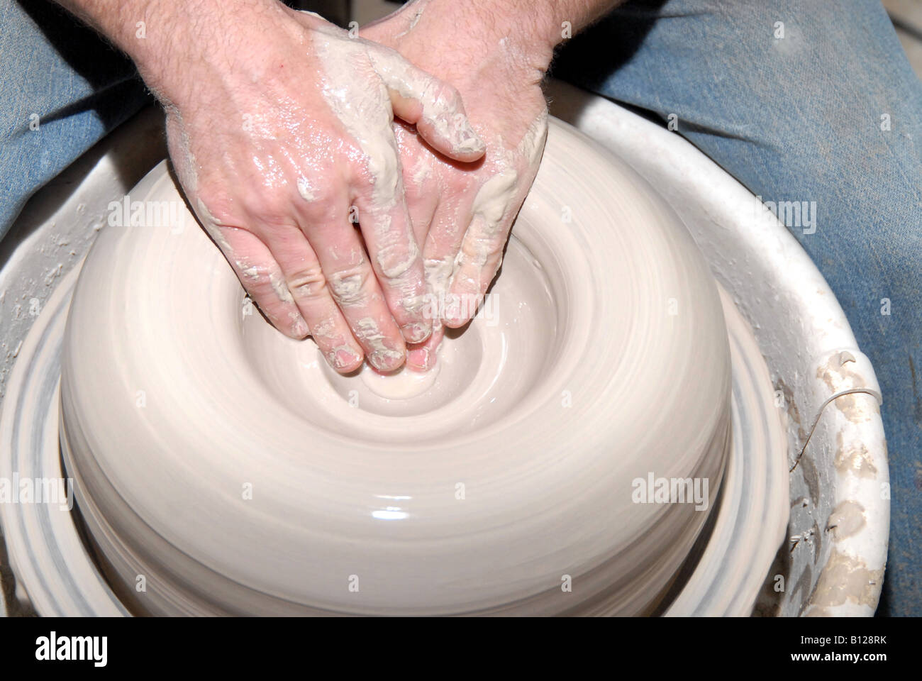 Potter forming large bowl with hands on potter's wheel Stock Photo - Alamy