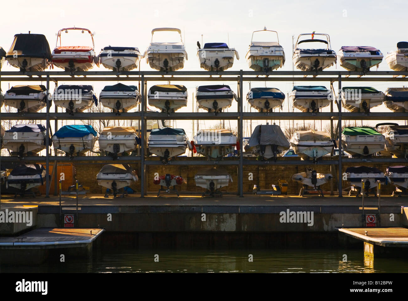 Speed boats and tenders racked and stacked for storage at a marina in ...