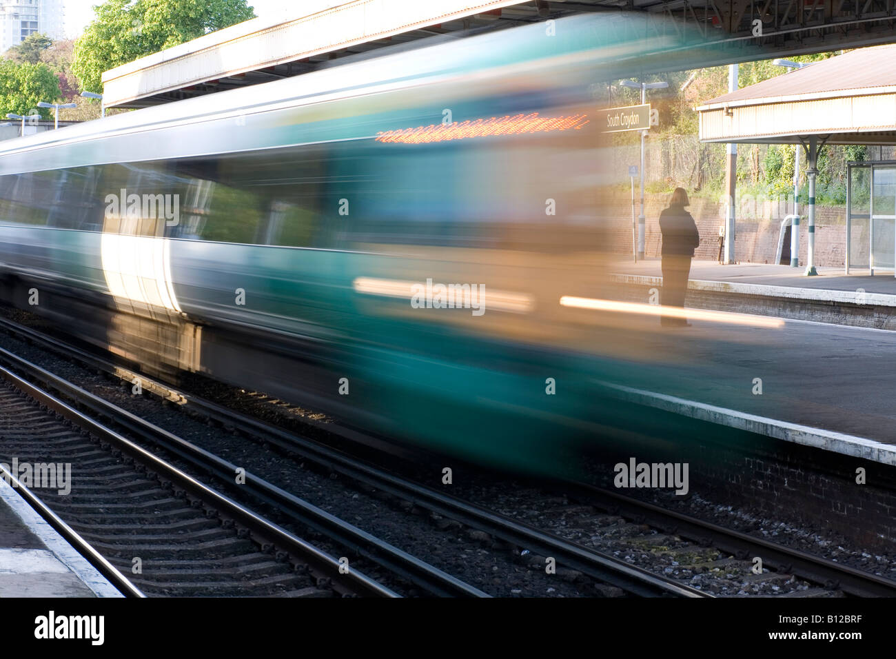 A train rushes passed at a south London station Stock Photo - Alamy
