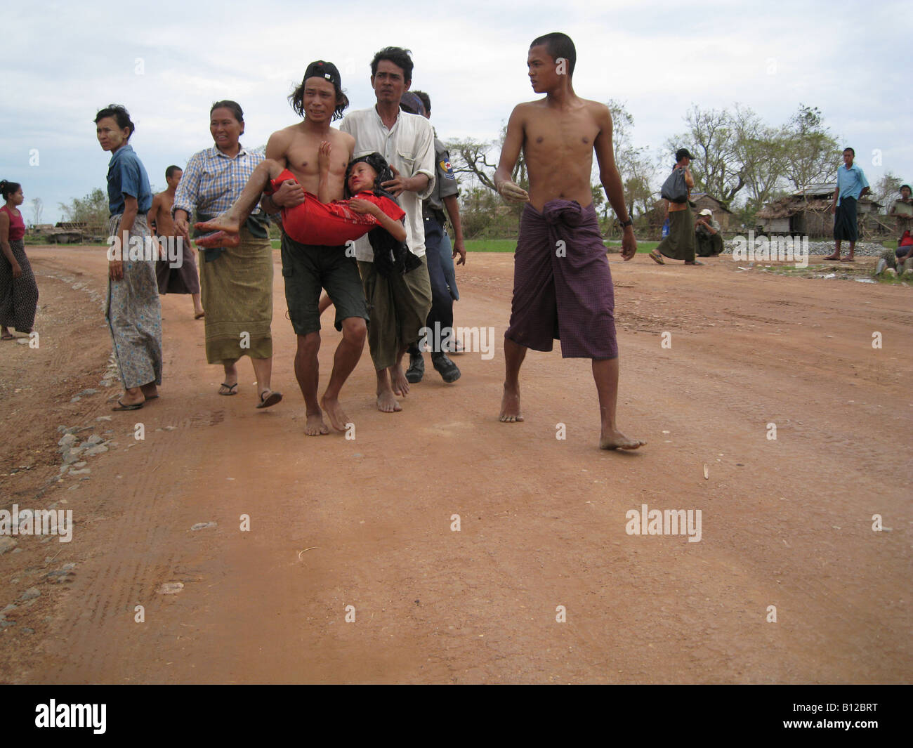 Cyclone Nargis survivors carry a wounded child on their way to Yangon ...
