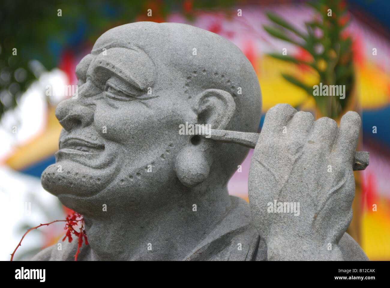 Stone statue of monk cleaning ear Stock Photo - Alamy