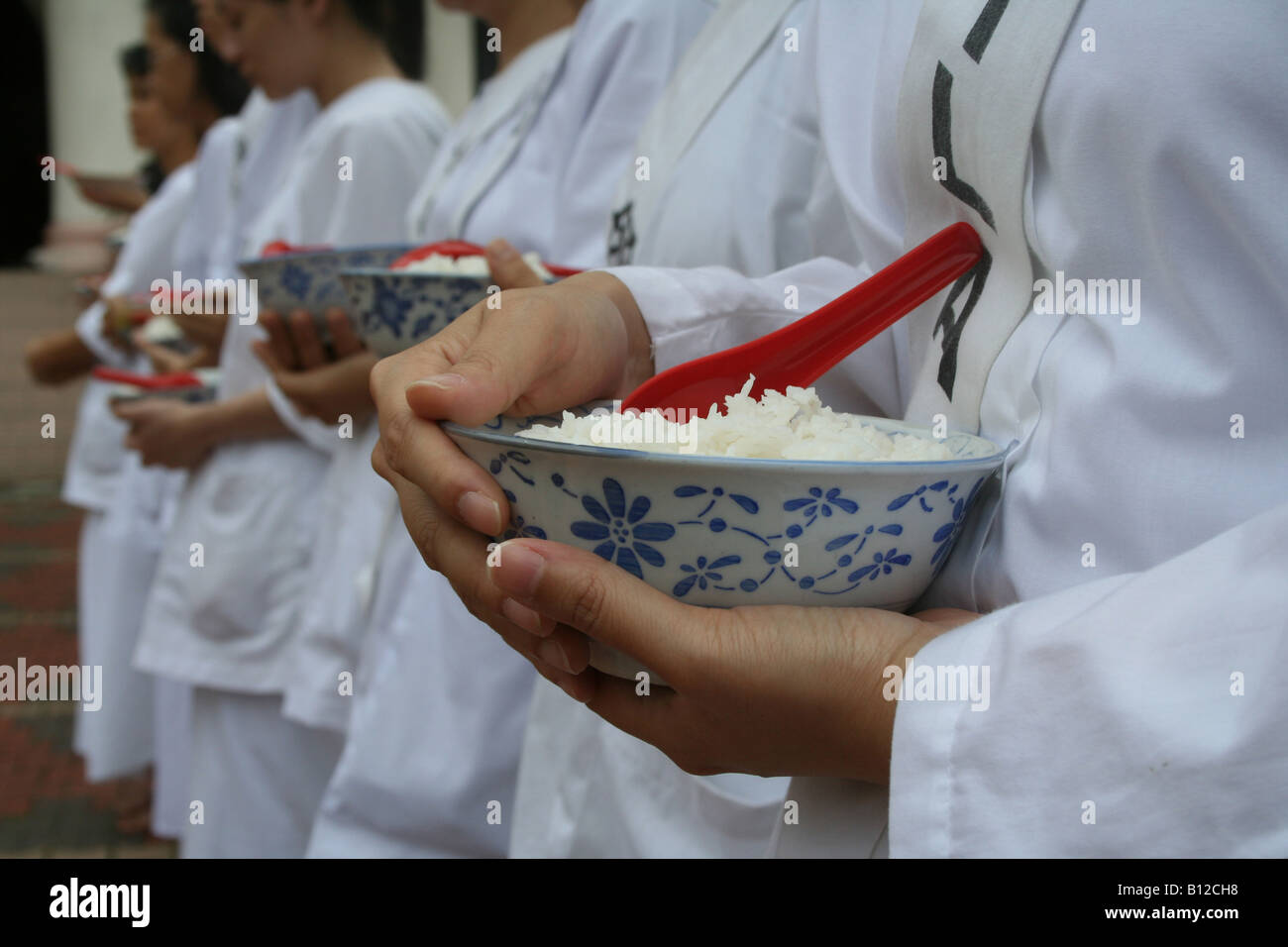 Devotees hands holding bowl of rice for offering Stock Photo - Alamy