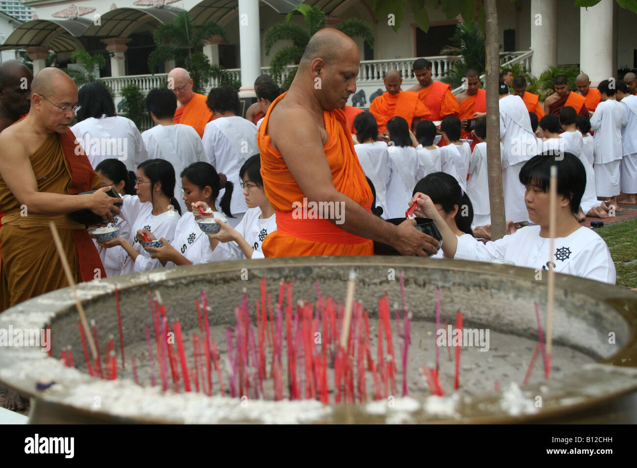 Monks receiving alms from devotees Stock Photo - Alamy