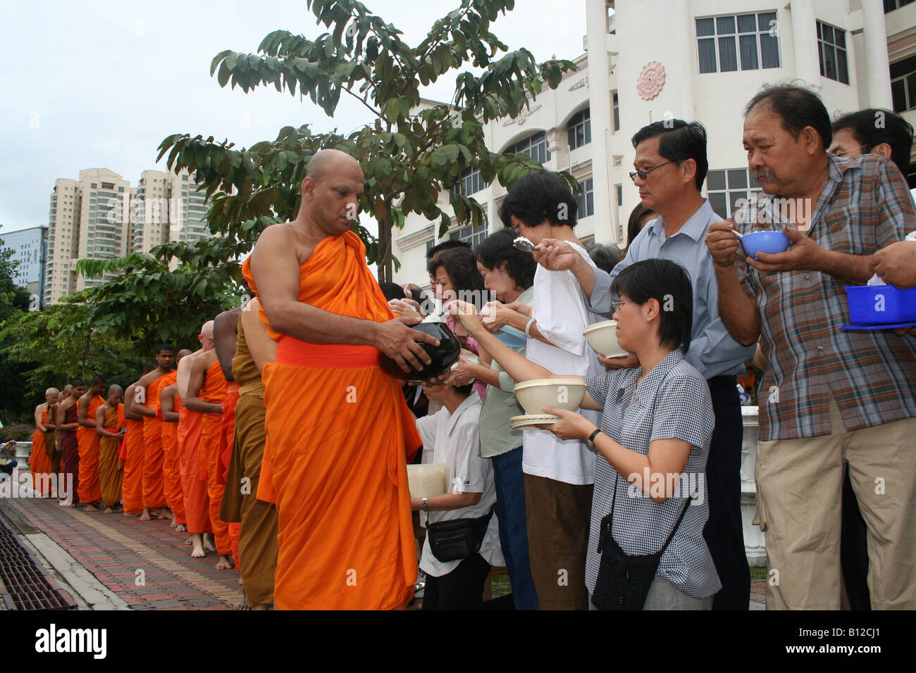 Monks receiving alms from devotees Stock Photo - Alamy