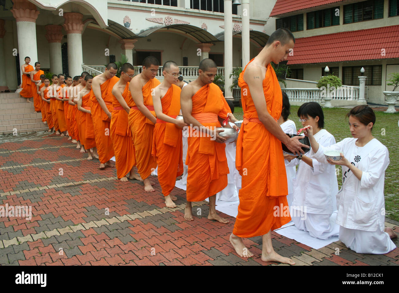 Buddhist monks line up receiving alms from devotees Stock Photo - Alamy