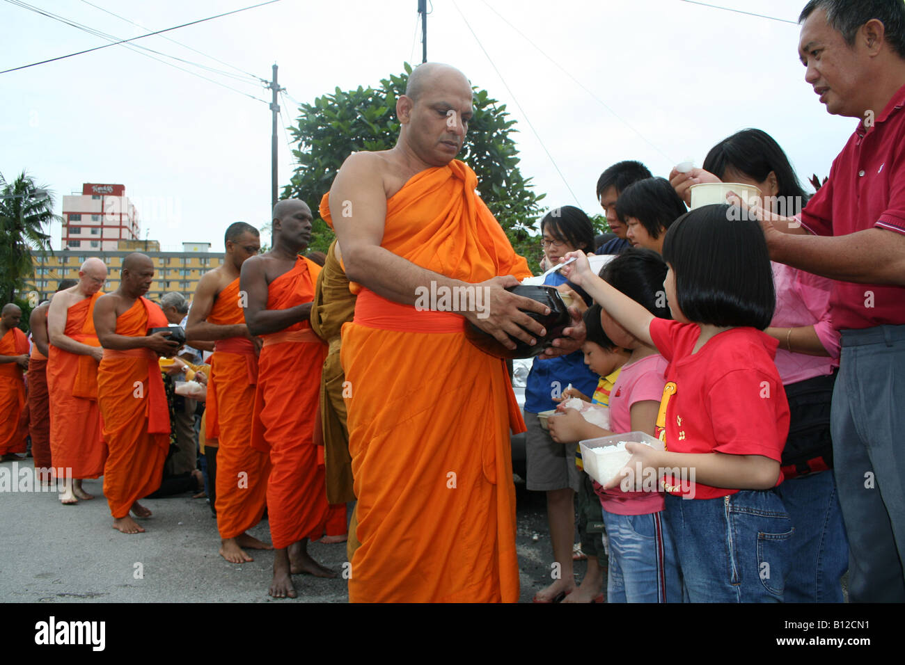 Buddhist monks receiving alms from devotees Stock Photo - Alamy