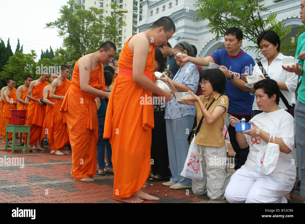 Buddhist devotees offering alms to monks Stock Photo - Alamy