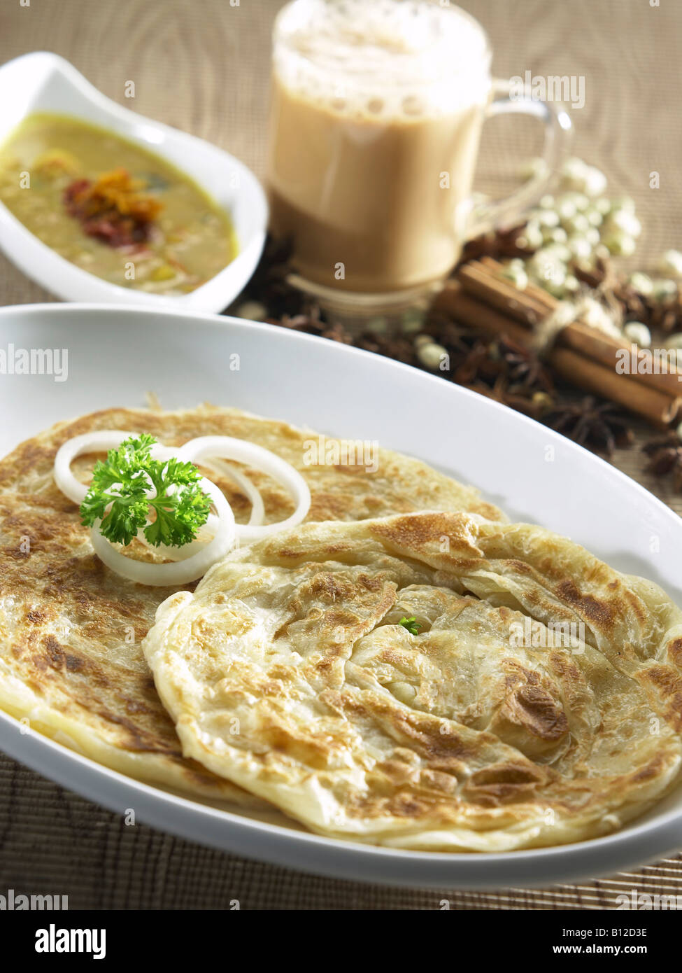 roti canai served with curry with teh tarik as background Stock Photo ...