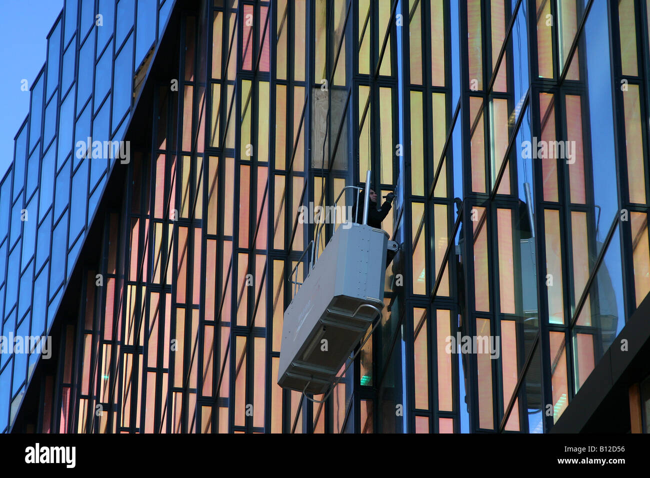 window cleaner cleaning windows of an office building Stock Photo - Alamy