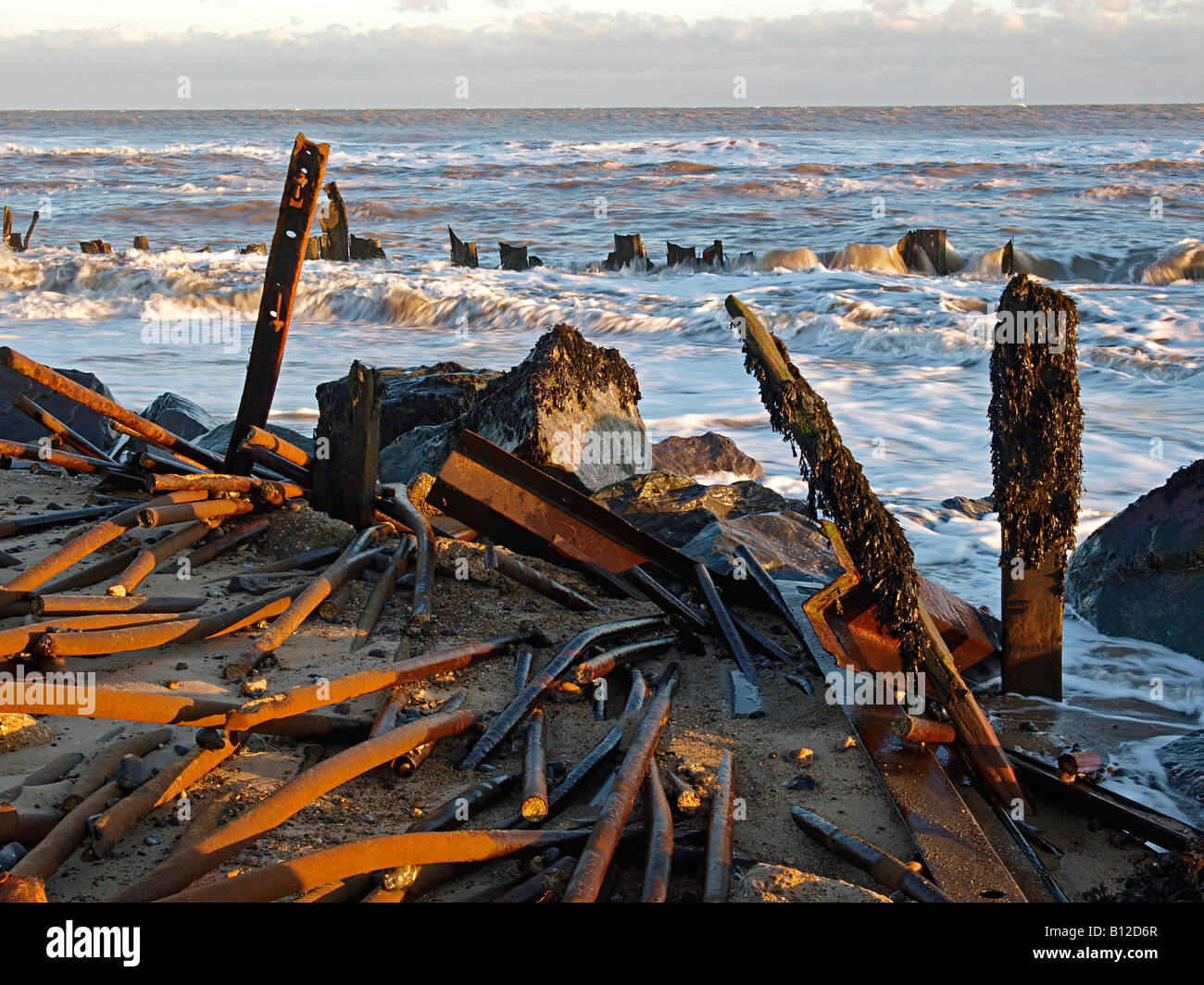 TWISTED METAL OF SEA DEFENCES AND SCAFFOLD POLES ON BEACH AT ...