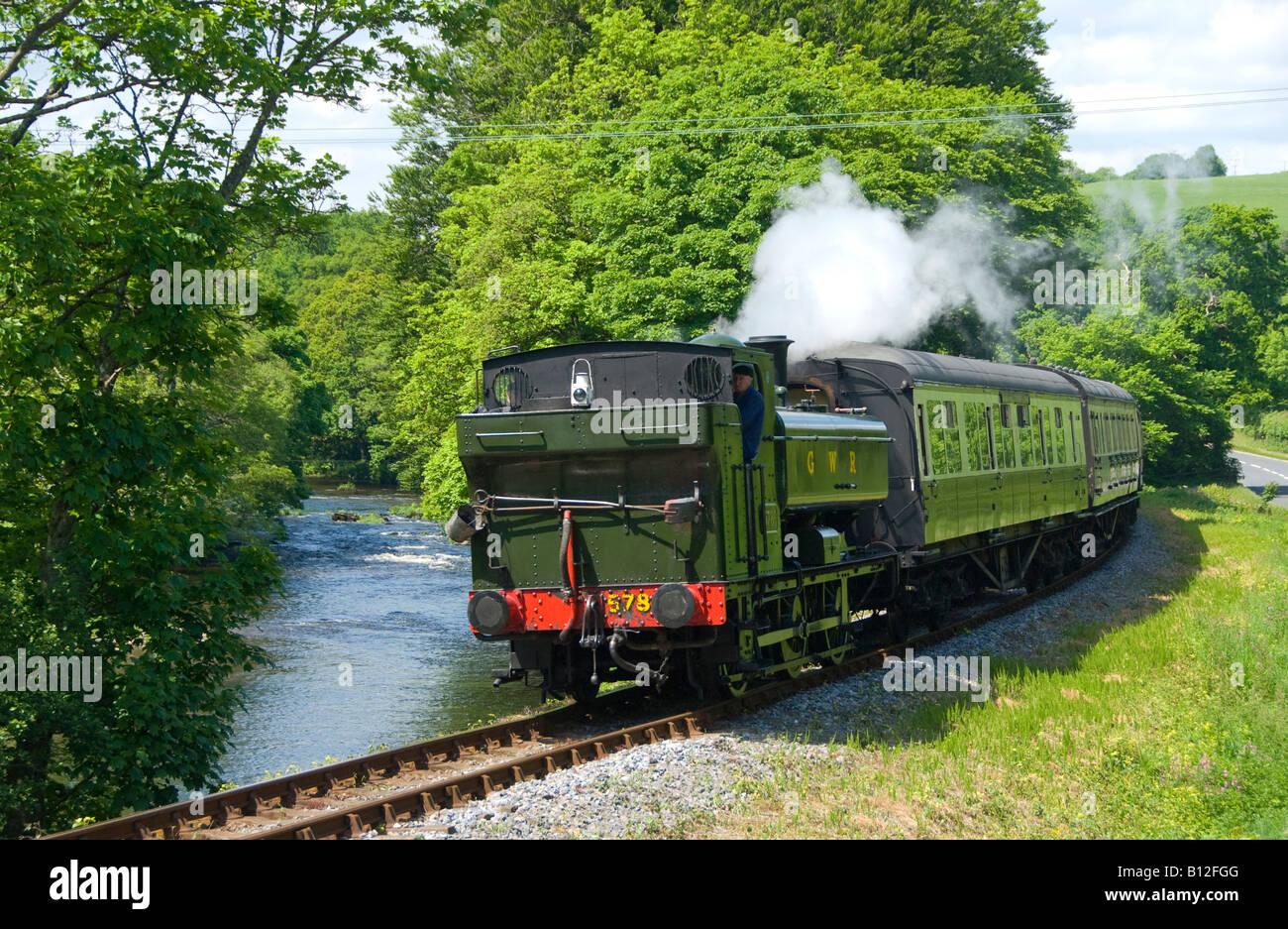 A steam train passes by the "river dart" along the South Devon Railway ...
