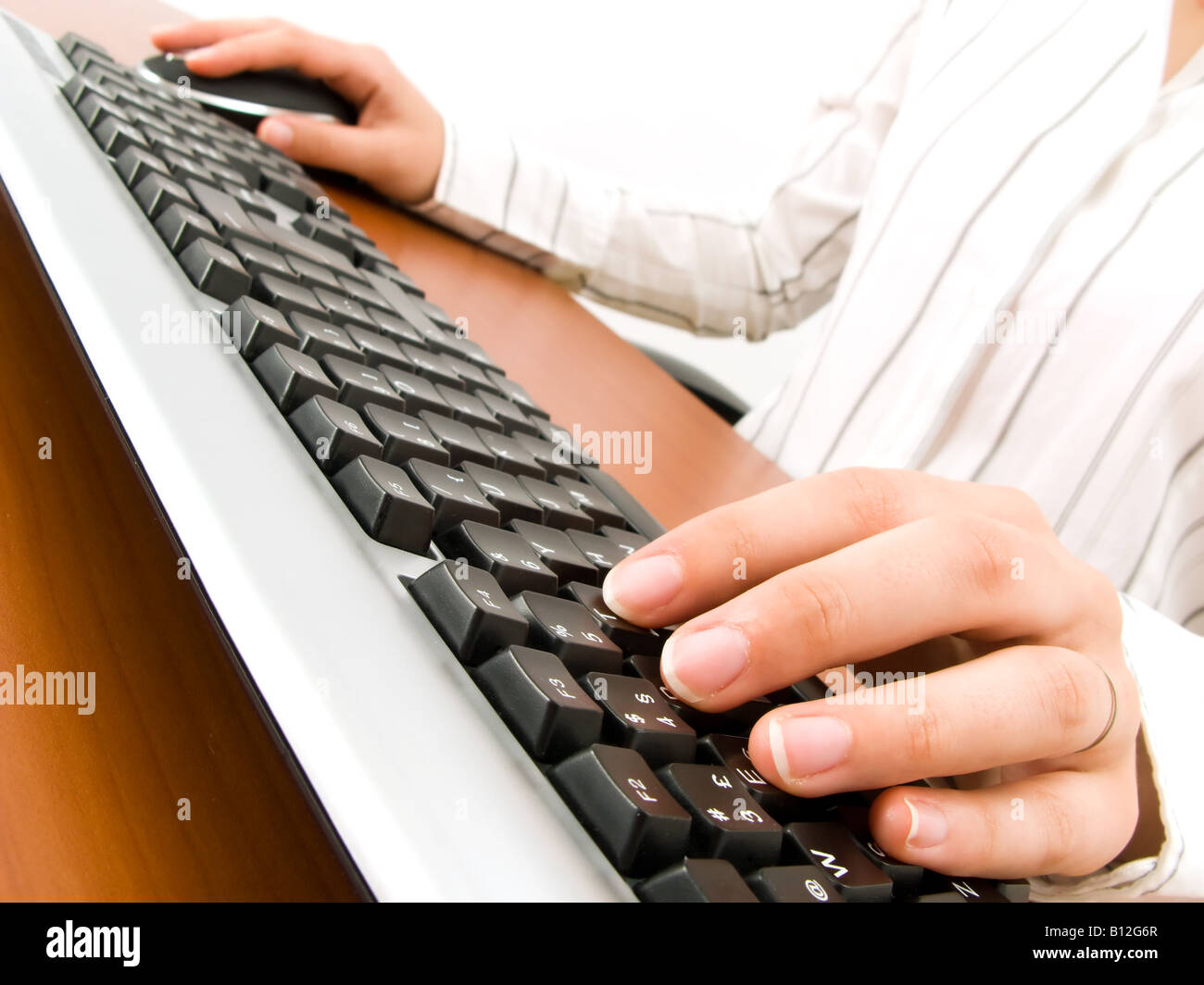 Businesswoman typing in the computer keyboard and using a mouse Stock ...