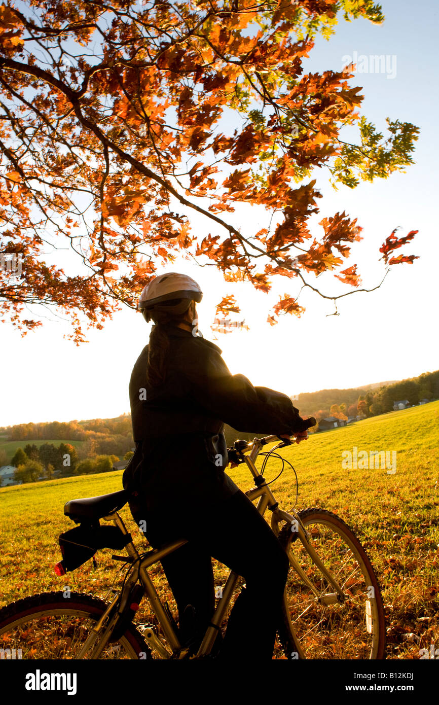 HEALTHY MIDDLE AGED MATURE OLDER WOMAN RIDING BIKE ALONE OUTDOORS ON ...