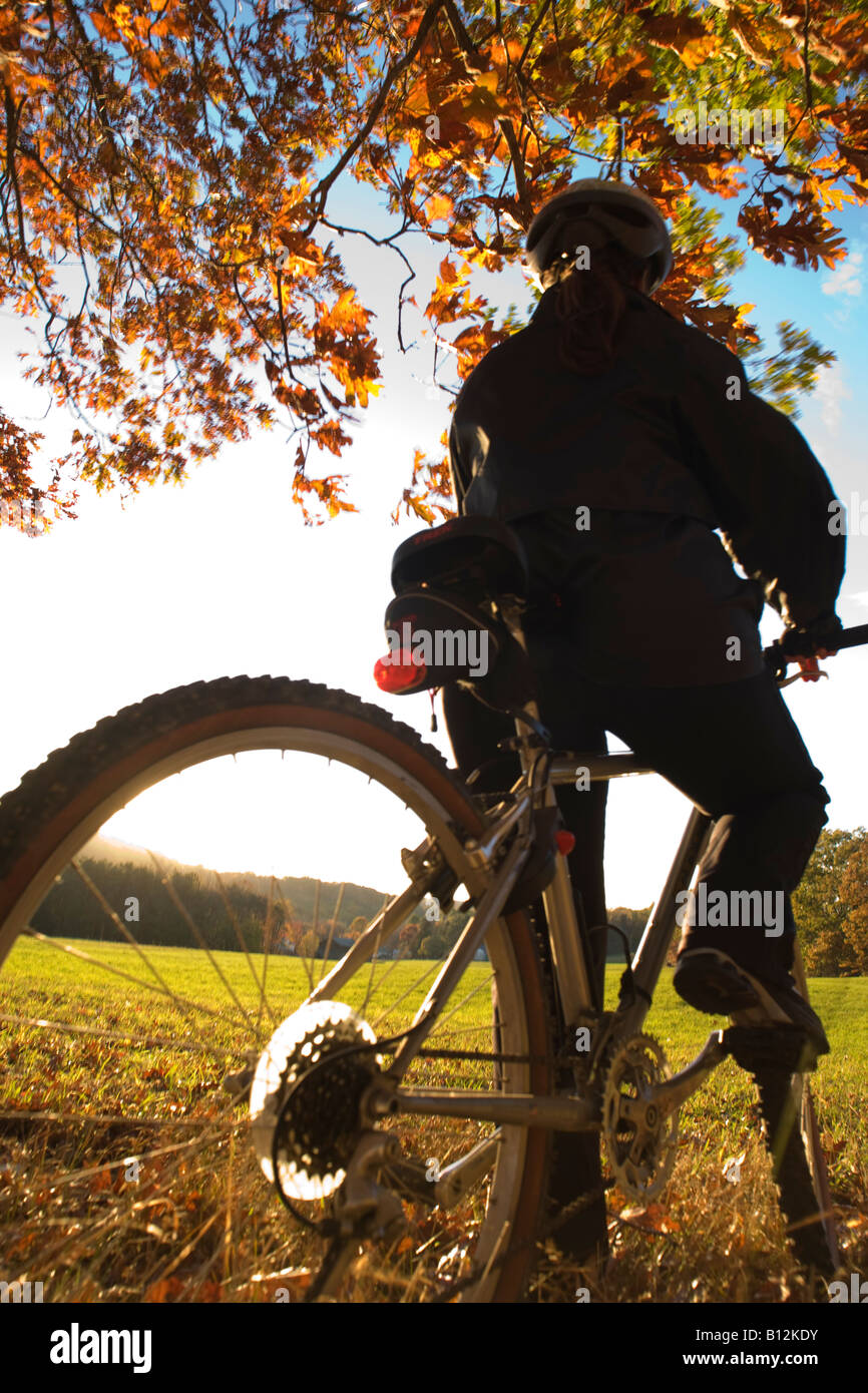 HEALTHY MIDDLE AGED MATURE OLDER WOMAN RIDING BIKE ALONE OUTDOORS ON ...