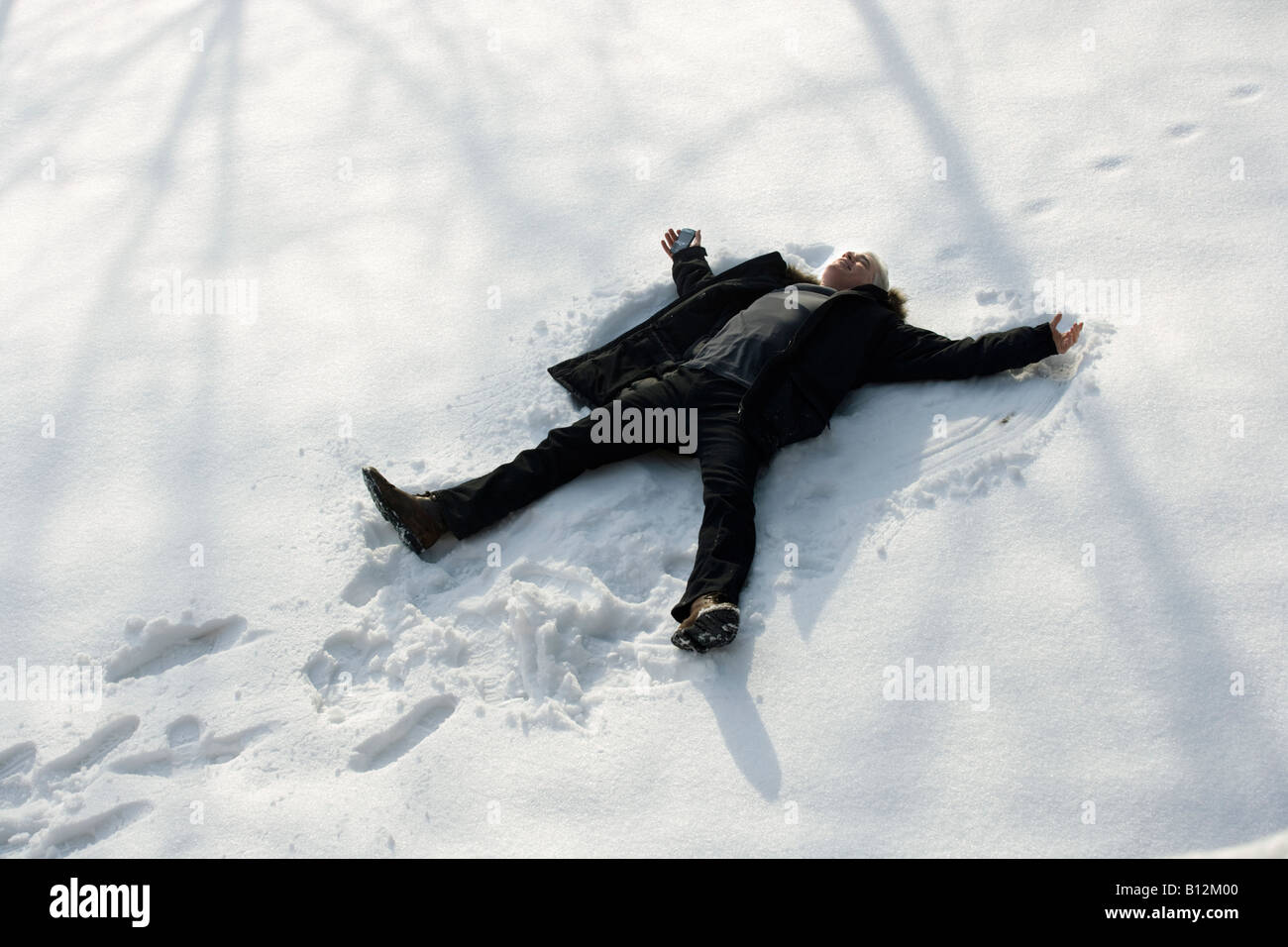 MIDDLE AGED MAN OUTSIDE IN SNOW COVERED FIELD MAKING SNOW ANGEL Stock ...