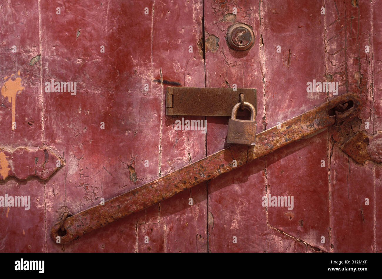 Worn, rusted set of red antique doors under lock key and padlock Stock ...