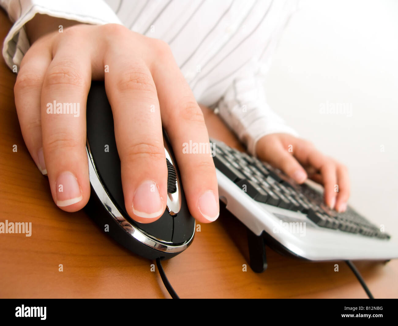Businesswoman typing in the computer keyboard and using a mouse Stock ...