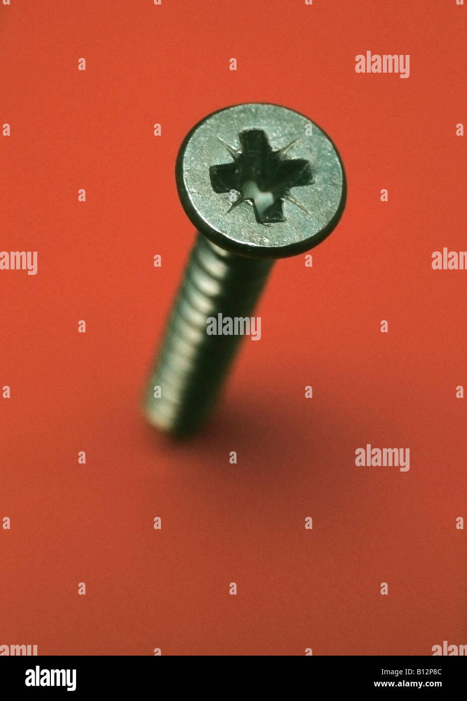 screwhead on red background Stock Photo - Alamy