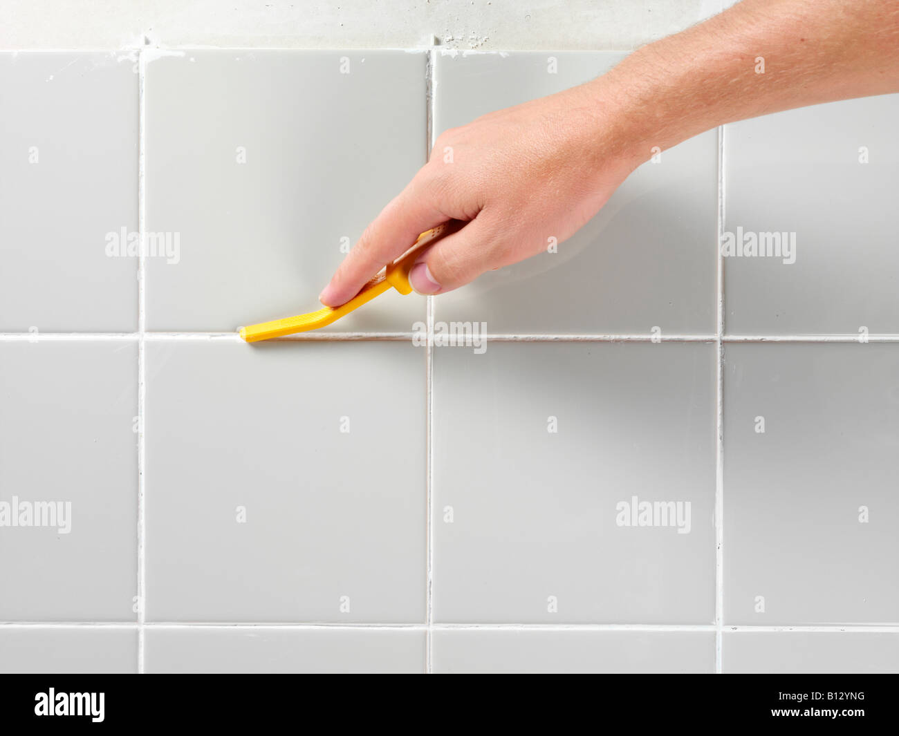 MAN TILING AND GROUTING WALL Stock Photo - Alamy
