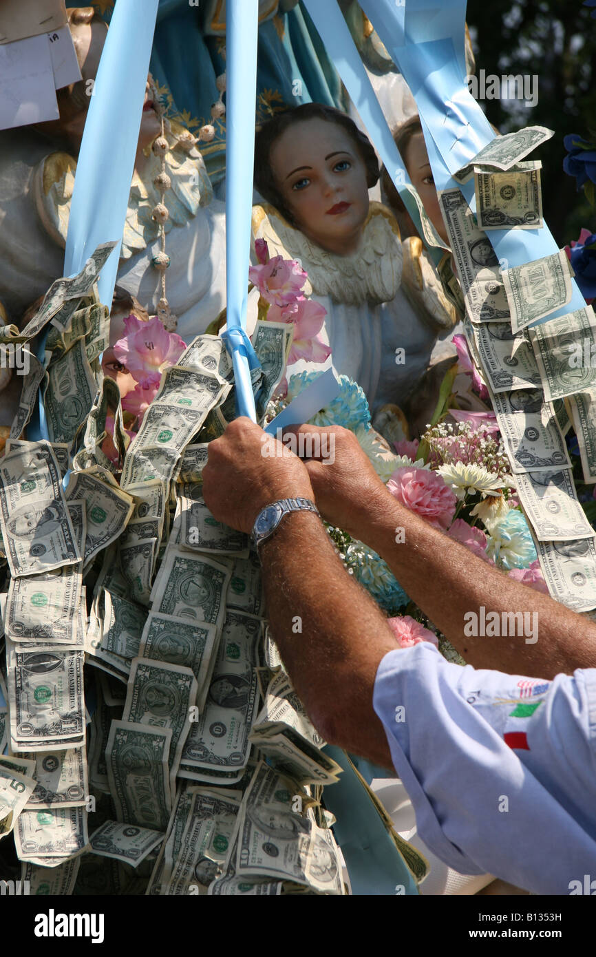 Pinning money on the sashes of a religious icon at an Italian parade ...