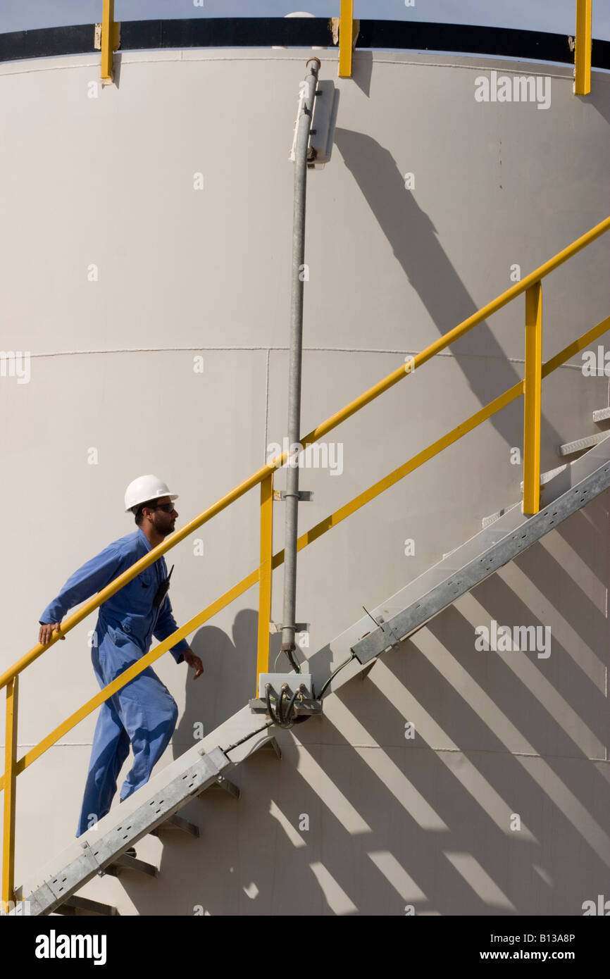 A worker climbs the stairs outside a tank. Bhit Gas Field Sindh ...