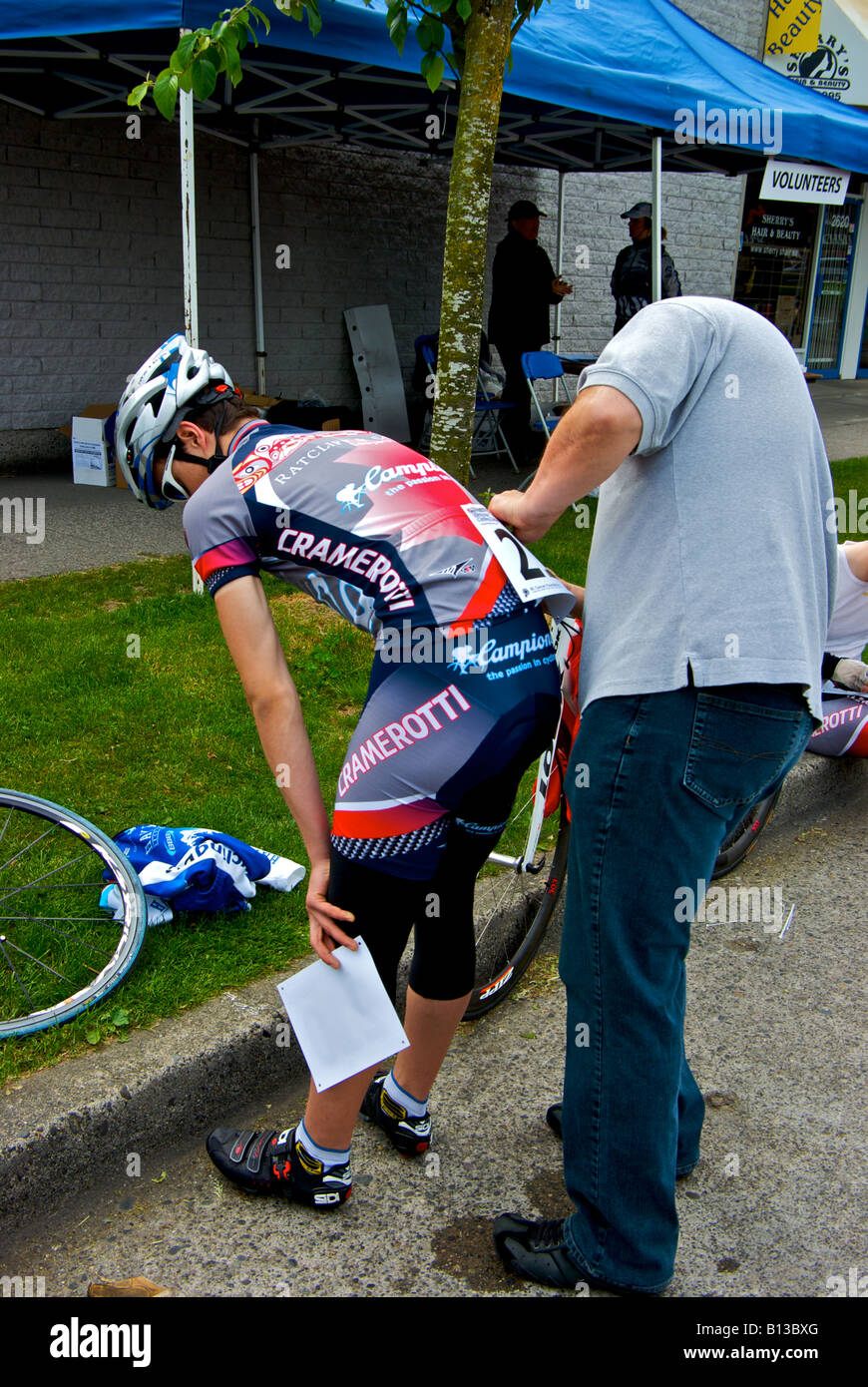 Bicycle team manager putting identification number on a male competitor ...