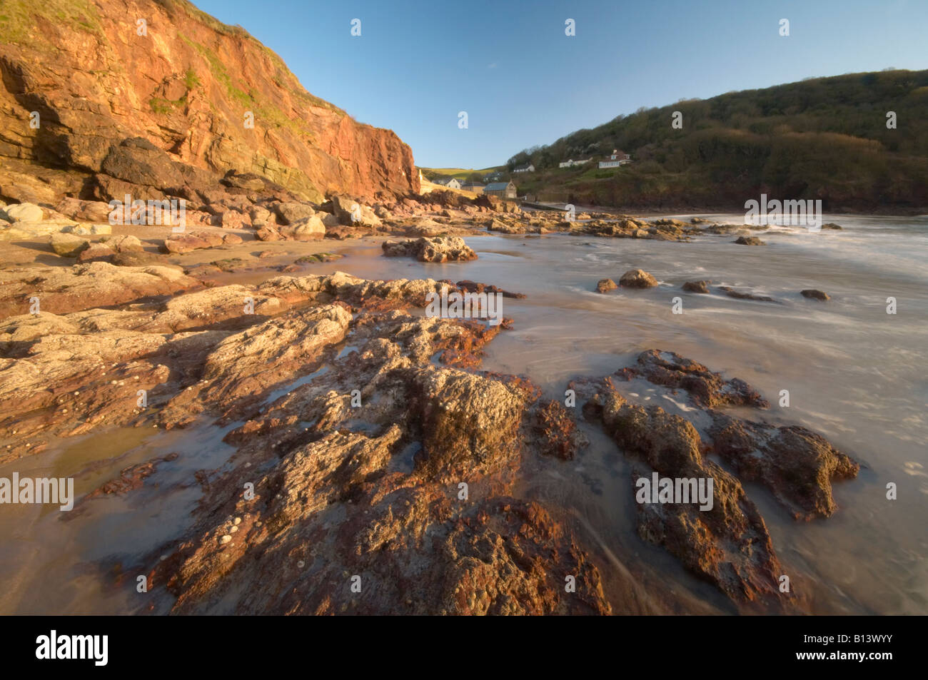High tide washing in over the shoreline rocks at sunset at Hope Cove ...