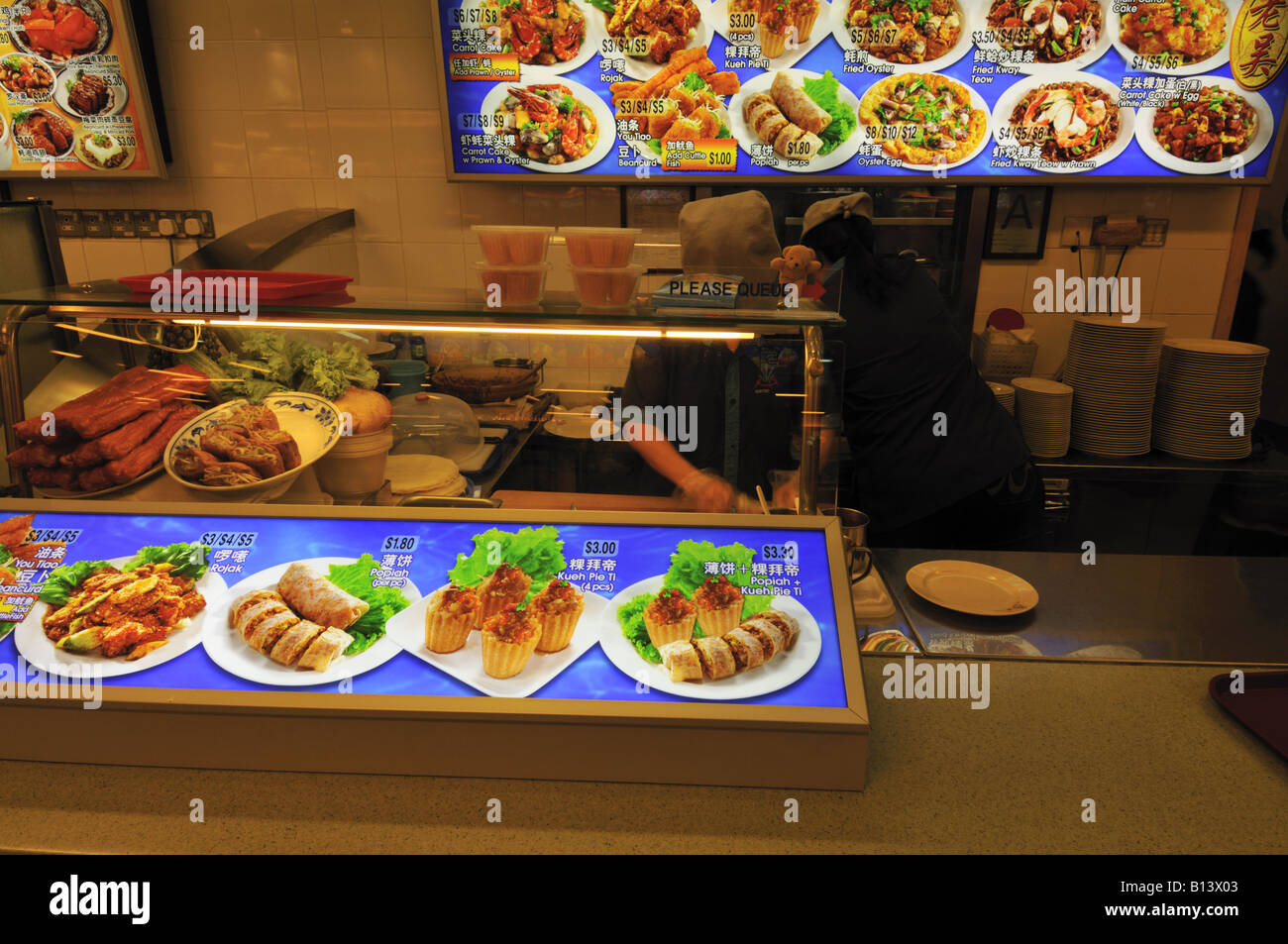 Local savory dishes on offer at a food court stall in Singapore Stock ...