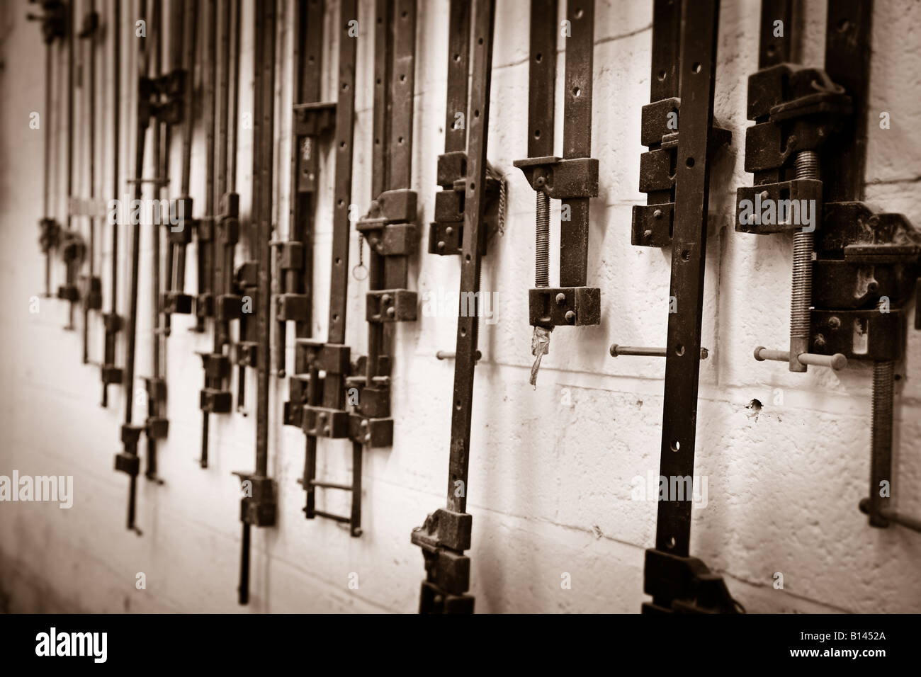 Workshop wall with metal clamps hanging on it Stock Photo - Alamy
