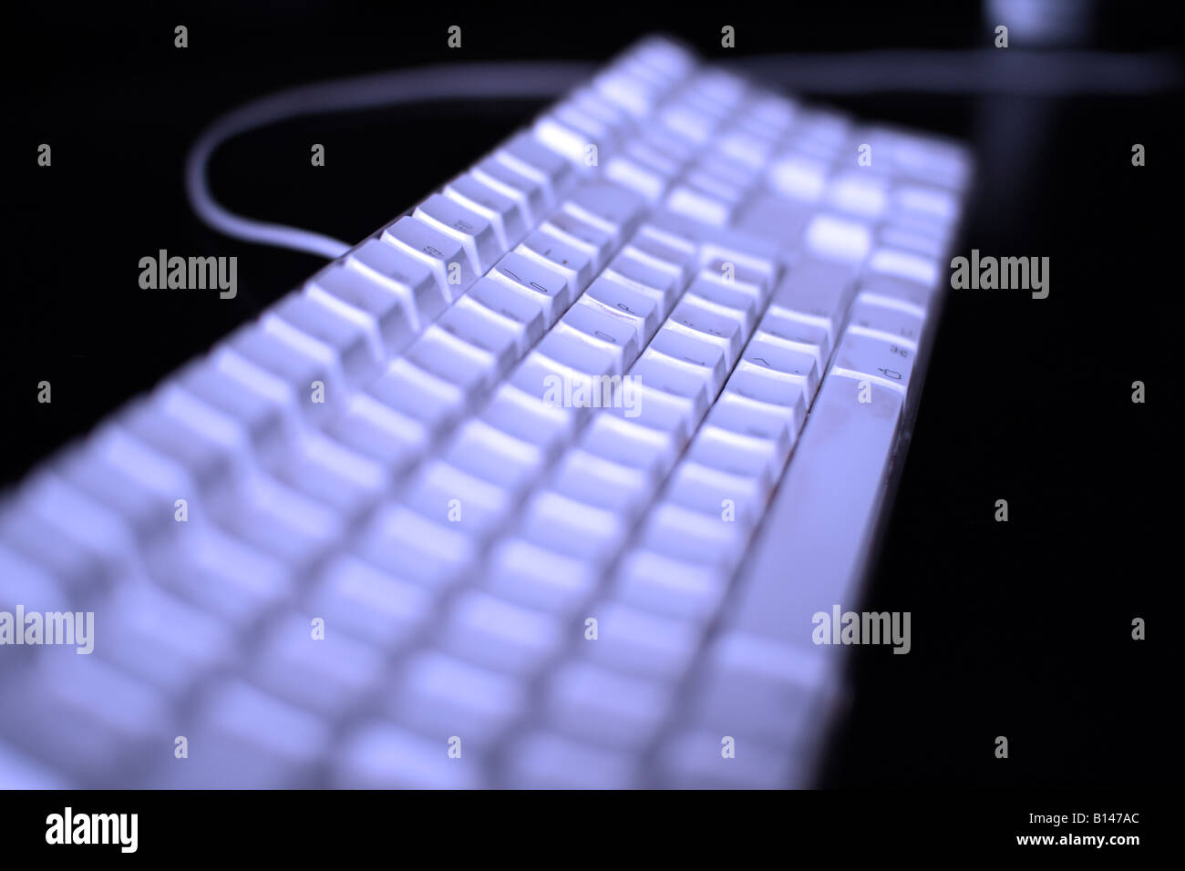 Computer keyboard, in a blue glow Stock Photo - Alamy