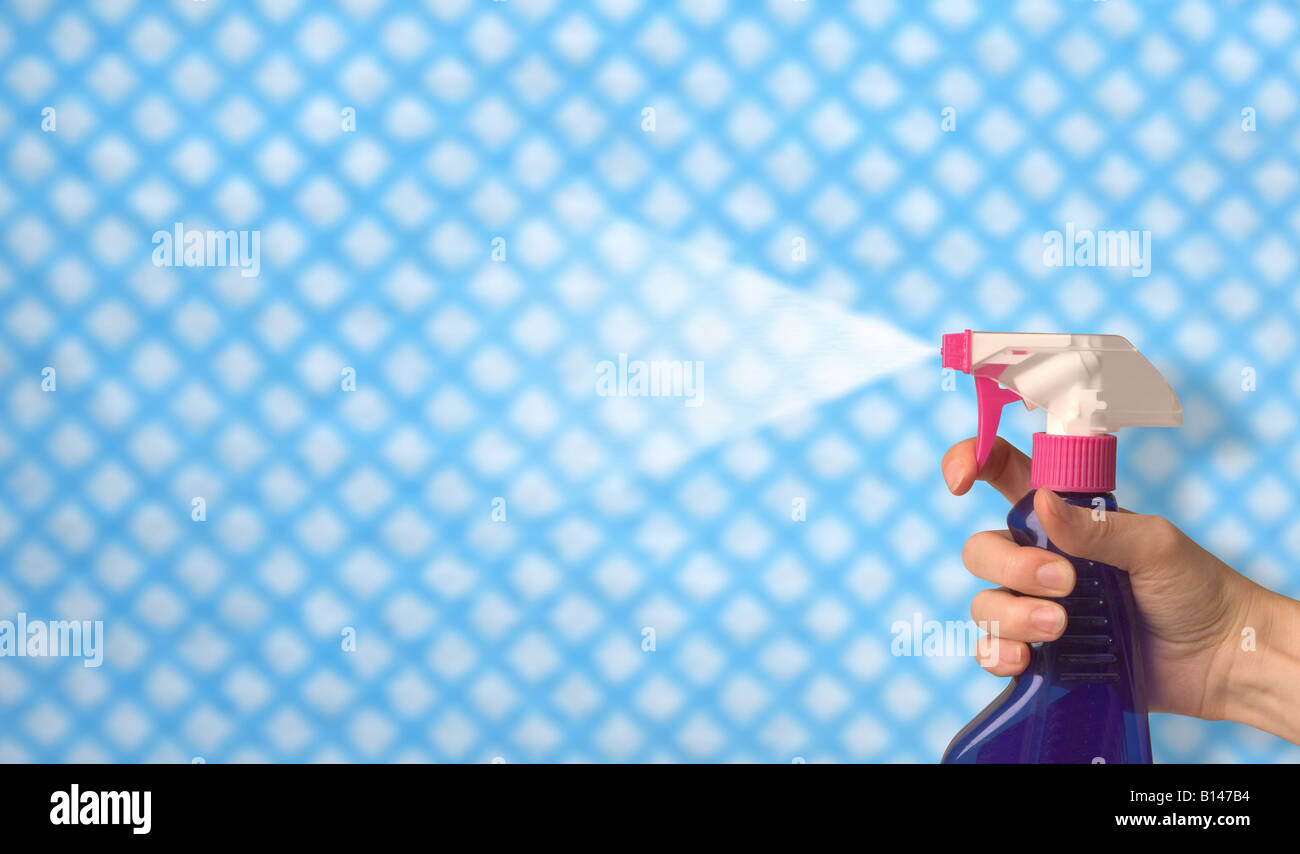 female hand spraying cleaning polish over a cloth background Stock ...