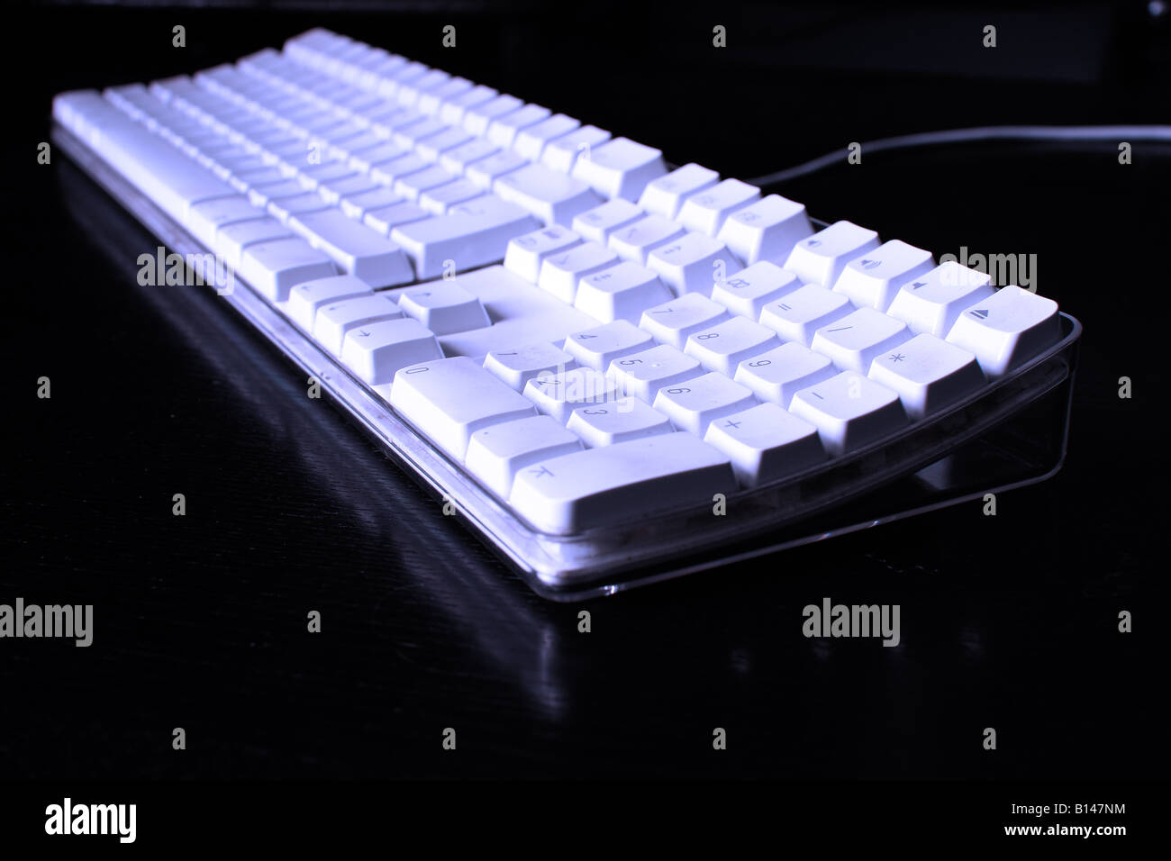Computer keyboard, in a blue glow Stock Photo - Alamy