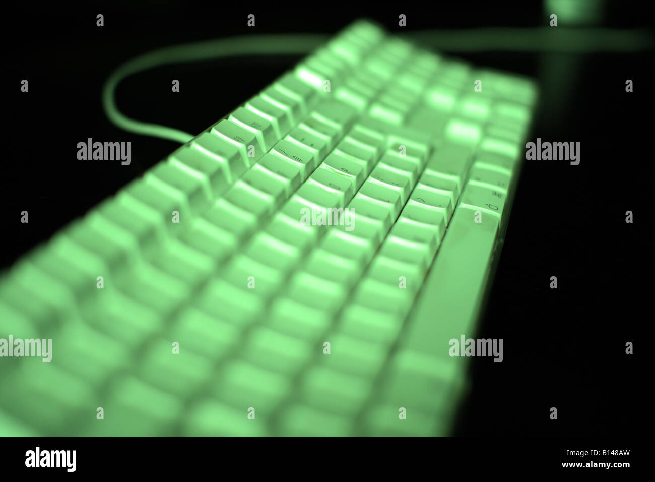 Computer keyboard, in a green glow Stock Photo - Alamy