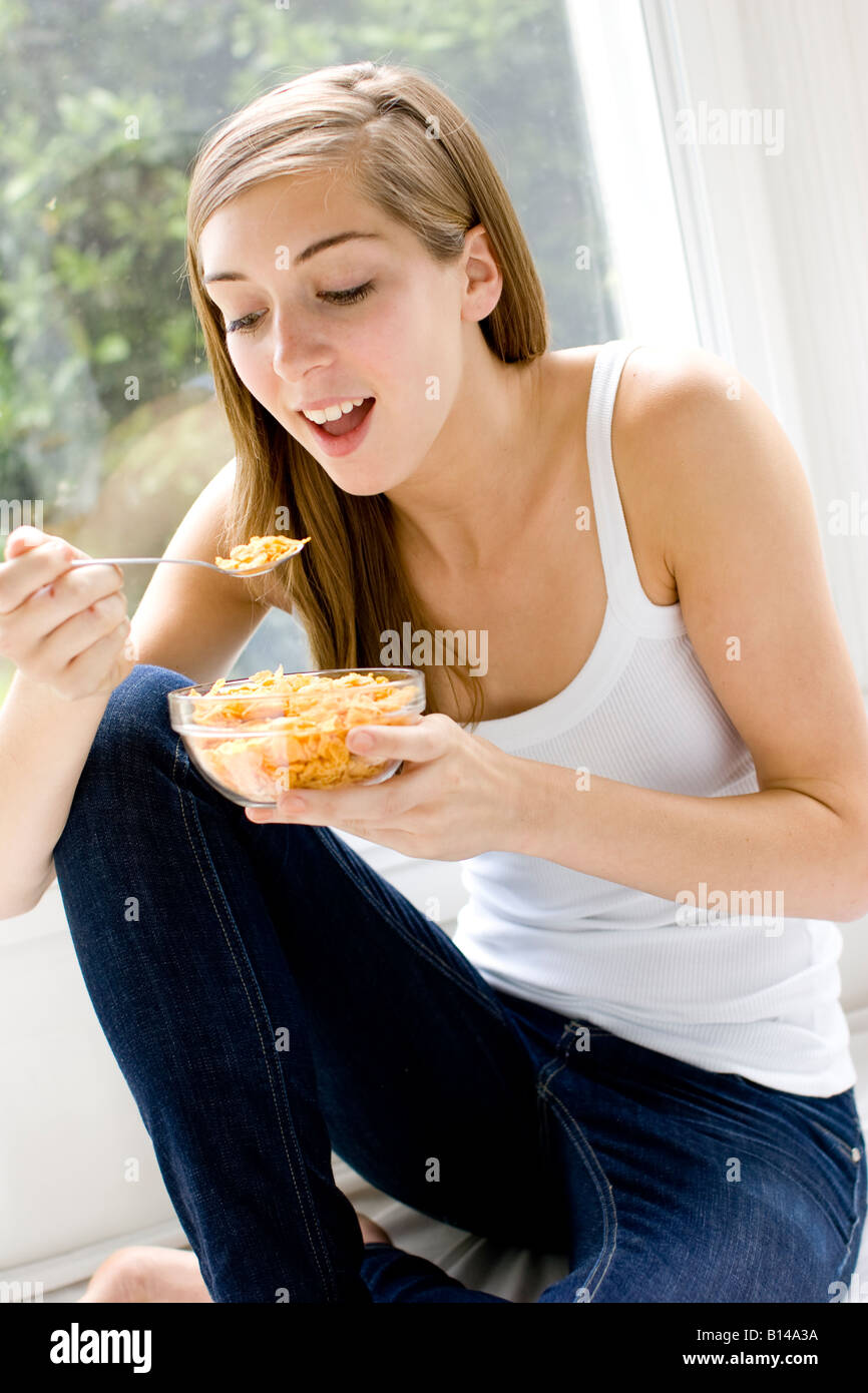 Brunette girl eating Cornflakes cereal Stock Photo - Alamy
