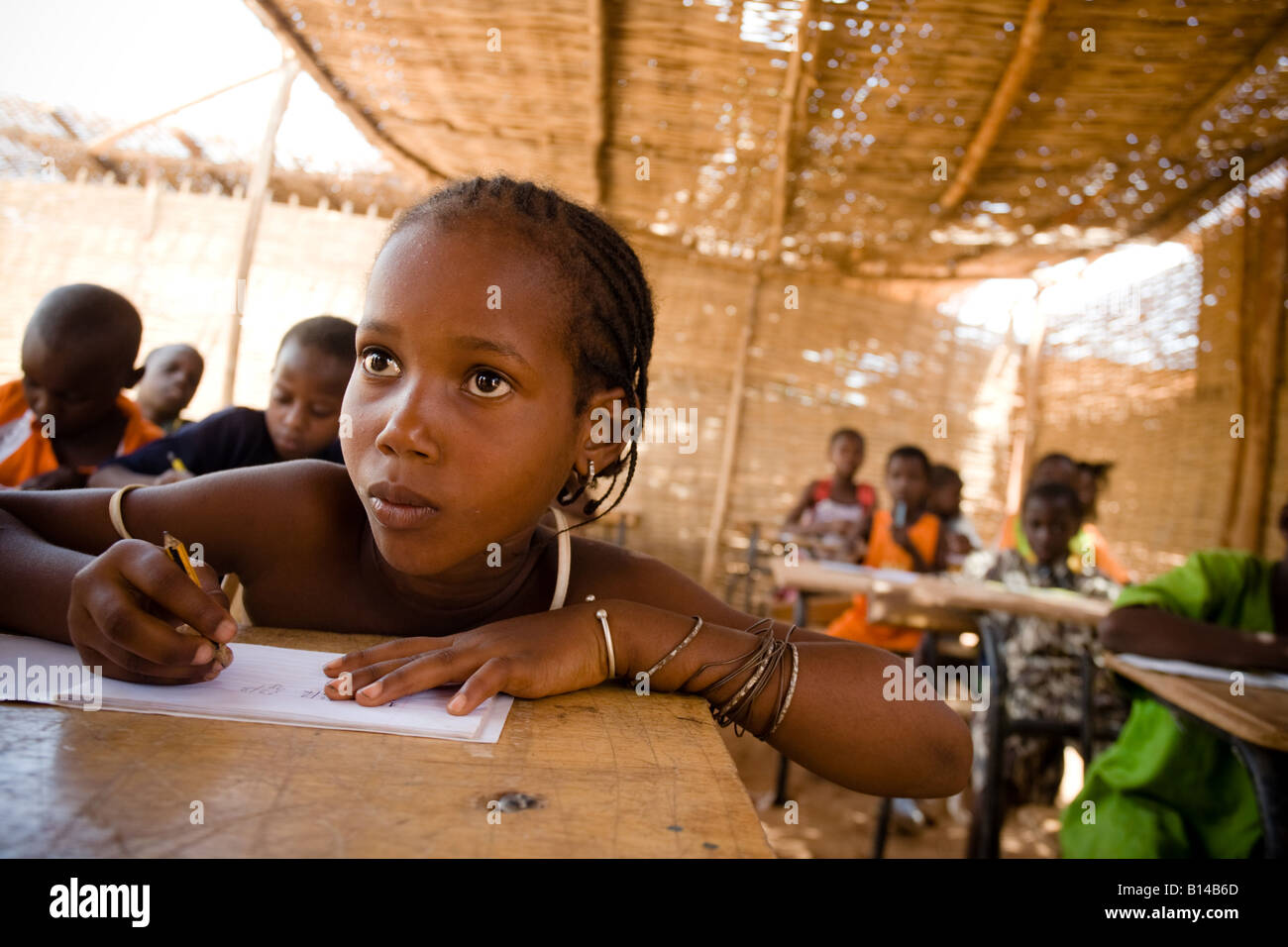 Girl writing in her school book during class Stock Photo - Alamy