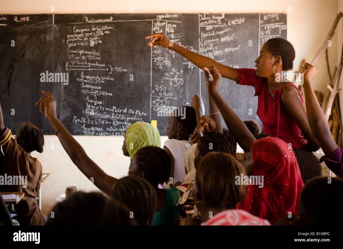 Children raise hands to answer a question during class Stock Photo - Alamy