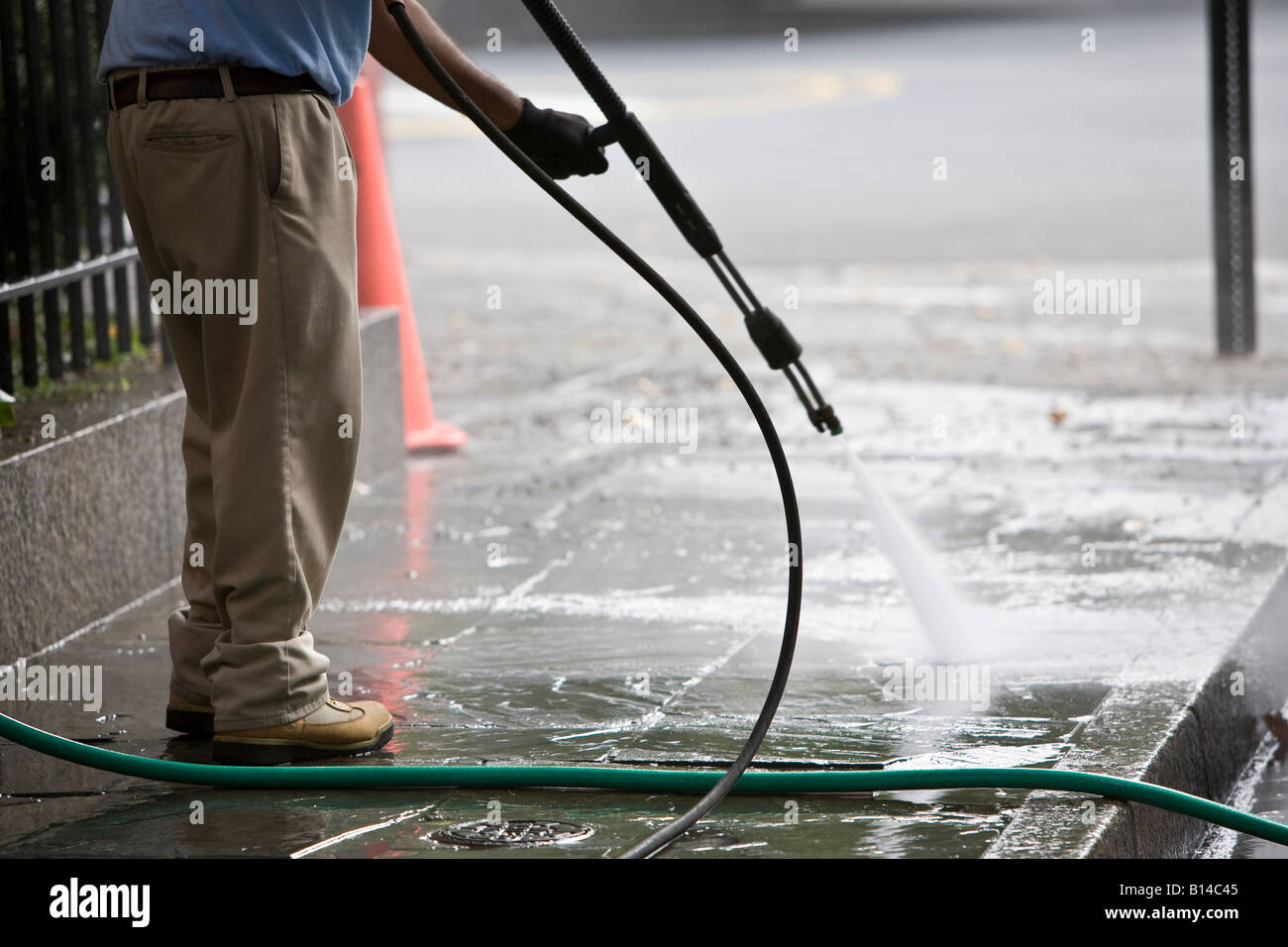 A worker power washing a sidewalk in New York City Stock Photo - Alamy
