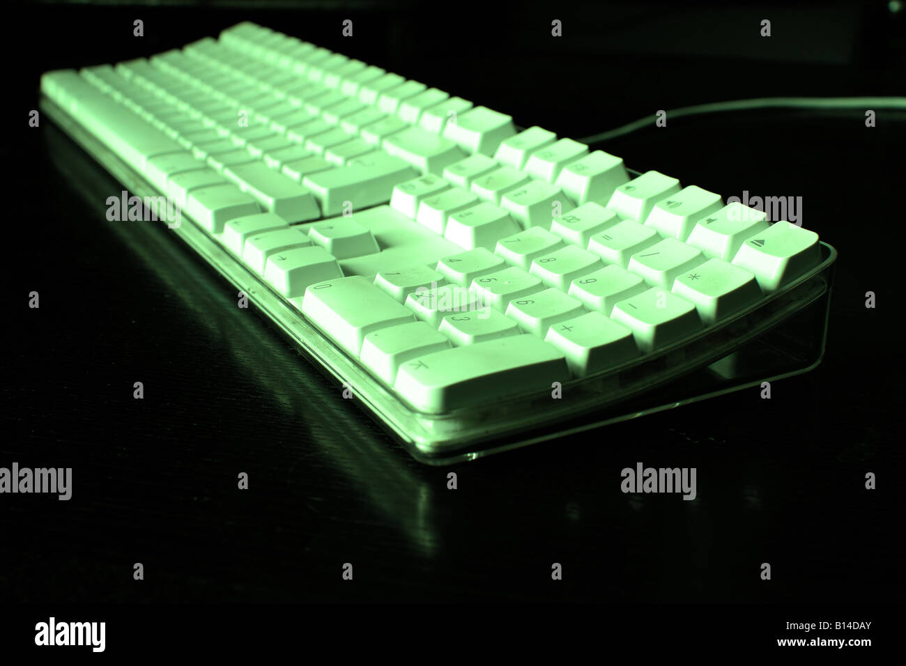 Computer keyboard, in a green glow Stock Photo - Alamy