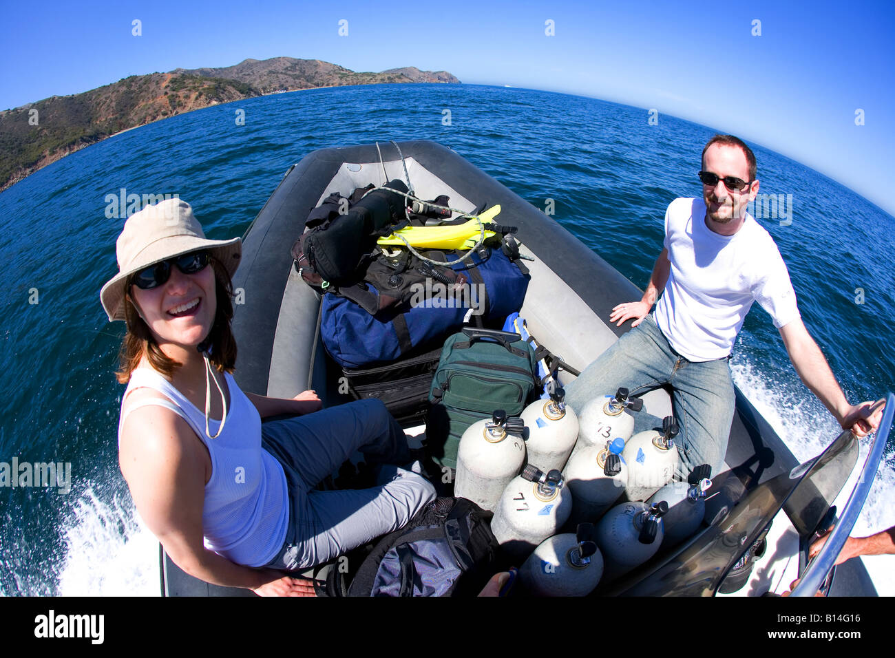 two SCUBA diving adventurers traveling on a small boat Stock Photo - Alamy