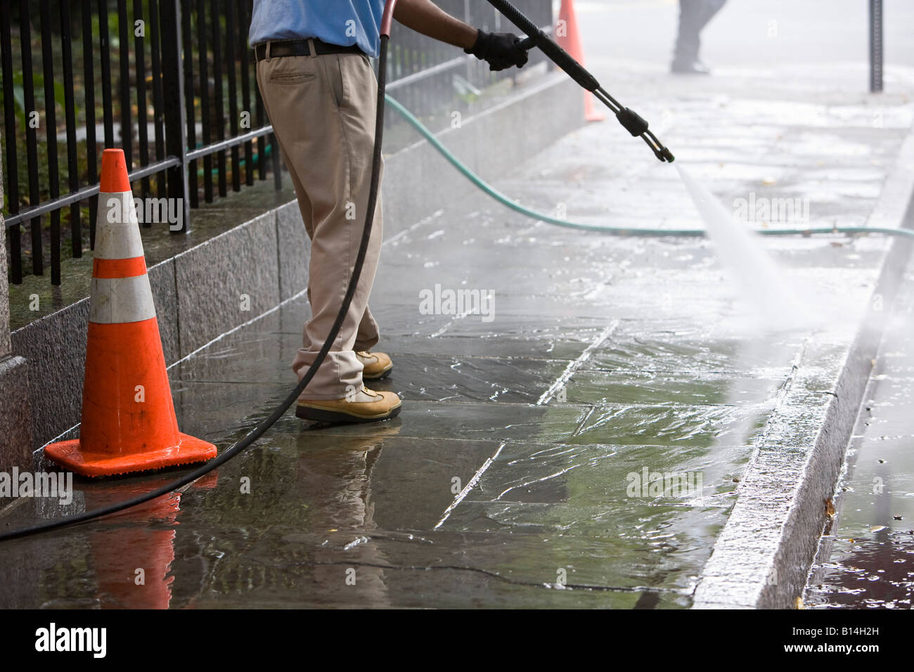 A worker power washing a sidewalk in New York City Stock Photo - Alamy
