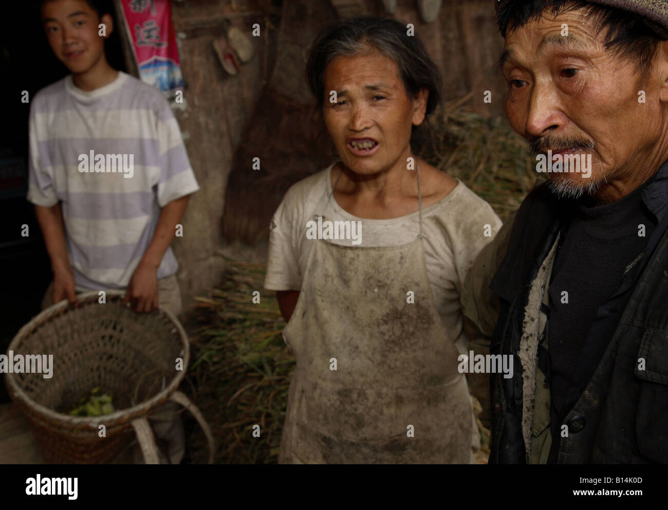A Chinese family pose for their photograph outside their small dwelling ...