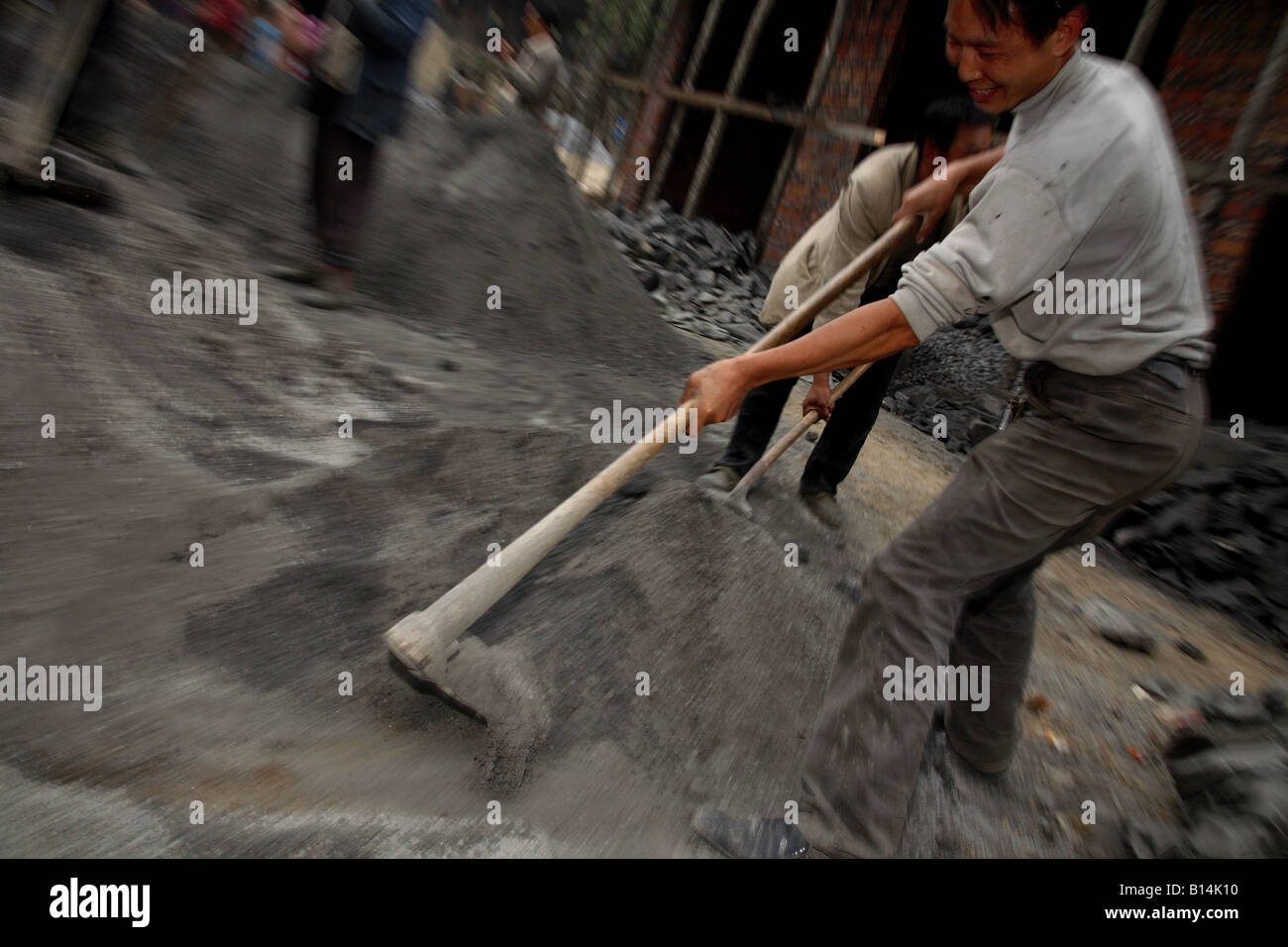 Chinese men shoveling sand and cement in a small village in Chongqing ...