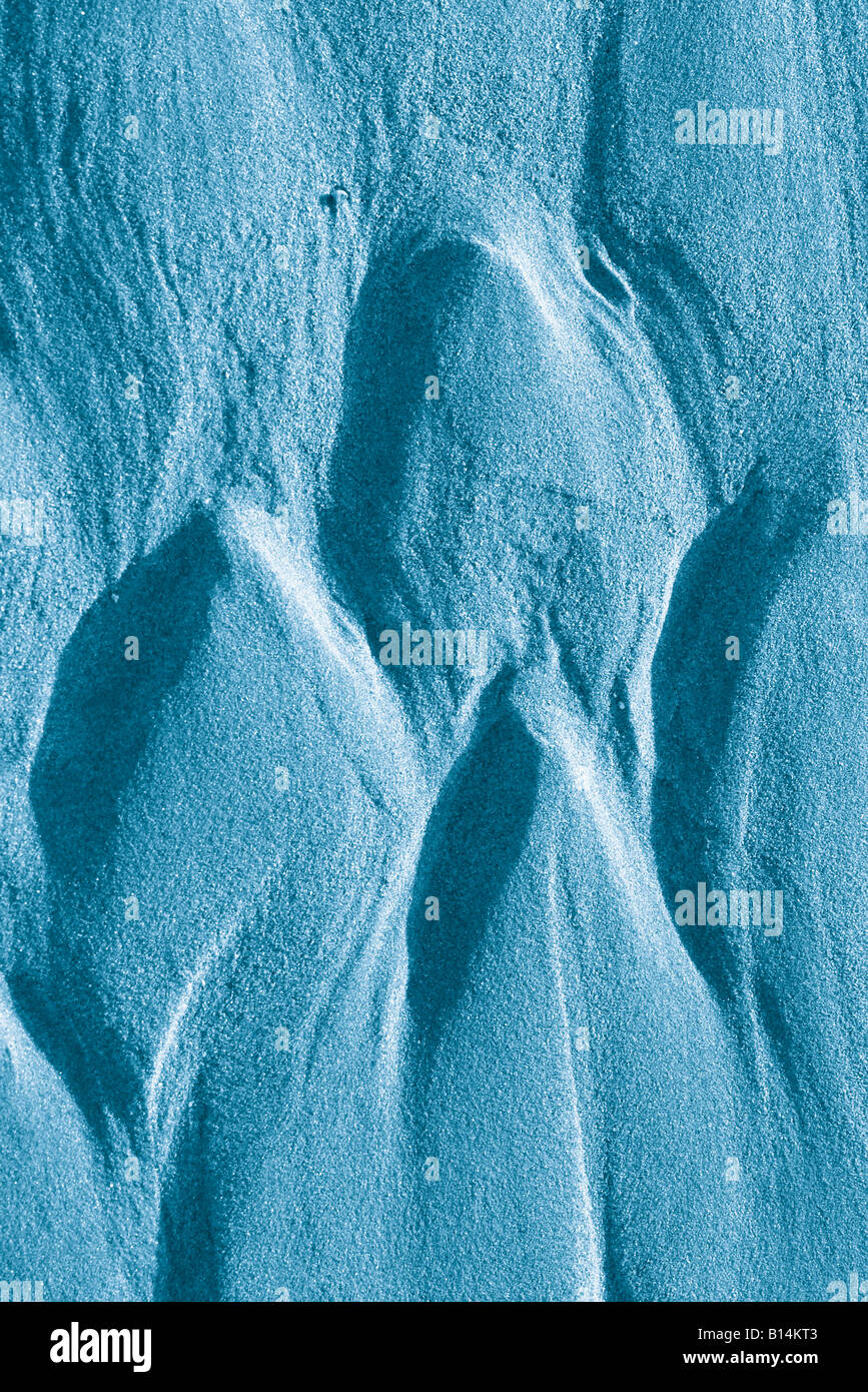 Beach at low tide, close up monochrome cyan image, sand pattern in a ...