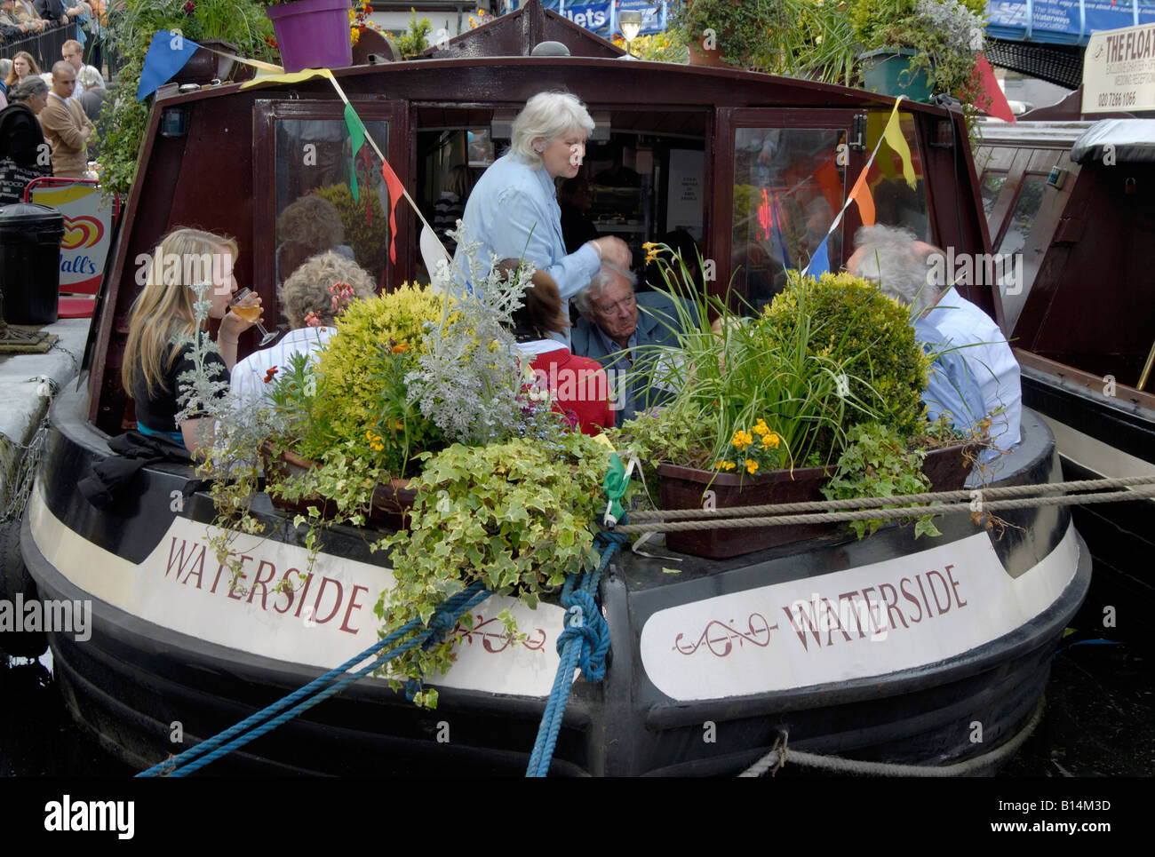 Floating pub: People enjoying a drink aboard flower bedecked bow of ...
