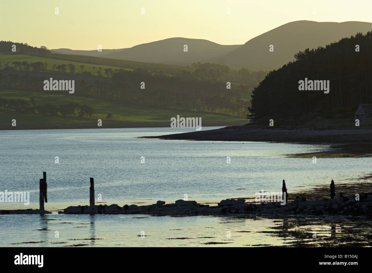 Evening on Loch Fleet at Little Ferry with still water and outline of ...